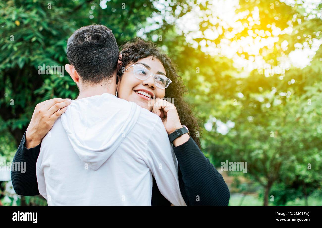Teenage couple hugging outdoors, Close up of happy couple hugging in ...