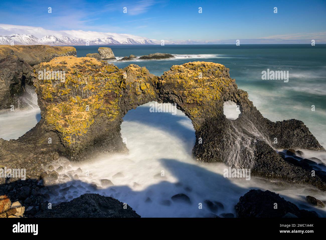 Gatklettur at sunrise, rock arch in the sea, Arnarstapi, Snaefellsnes ...