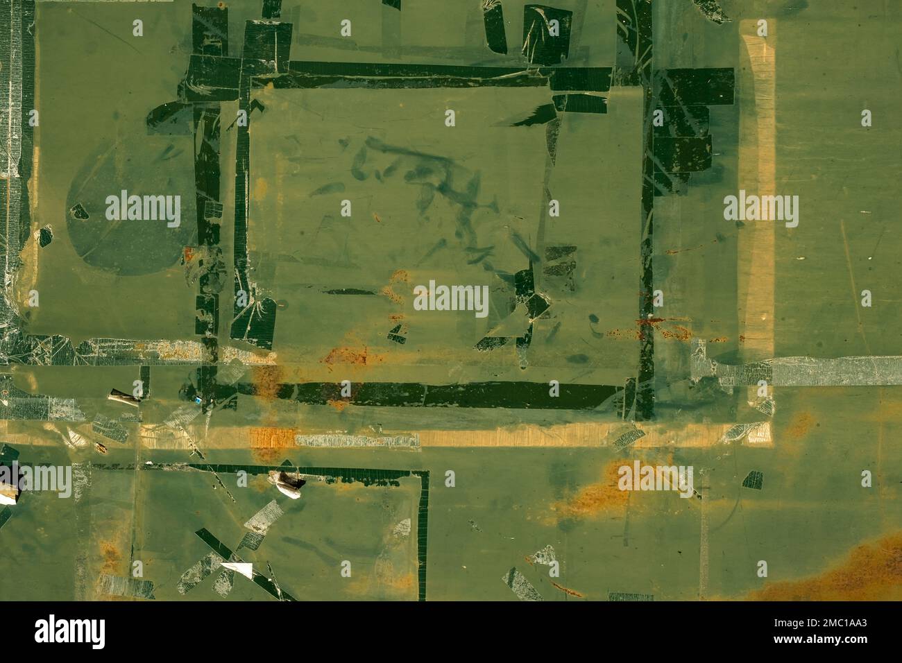Old green painted rusty metal plate with scraps of adhesive tape ...
