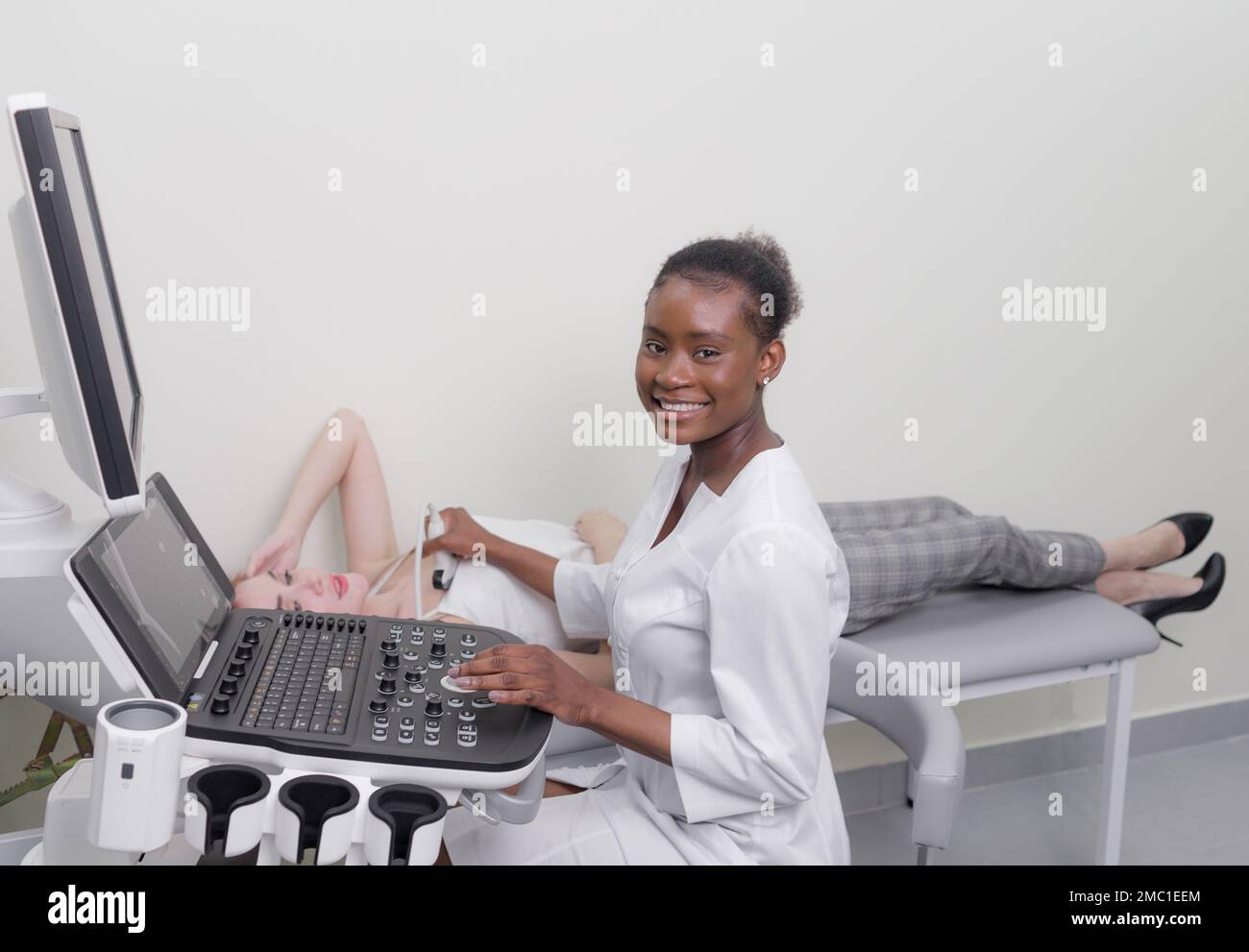 An African-American girl doctor undergoes an ultrasound scan of a ...