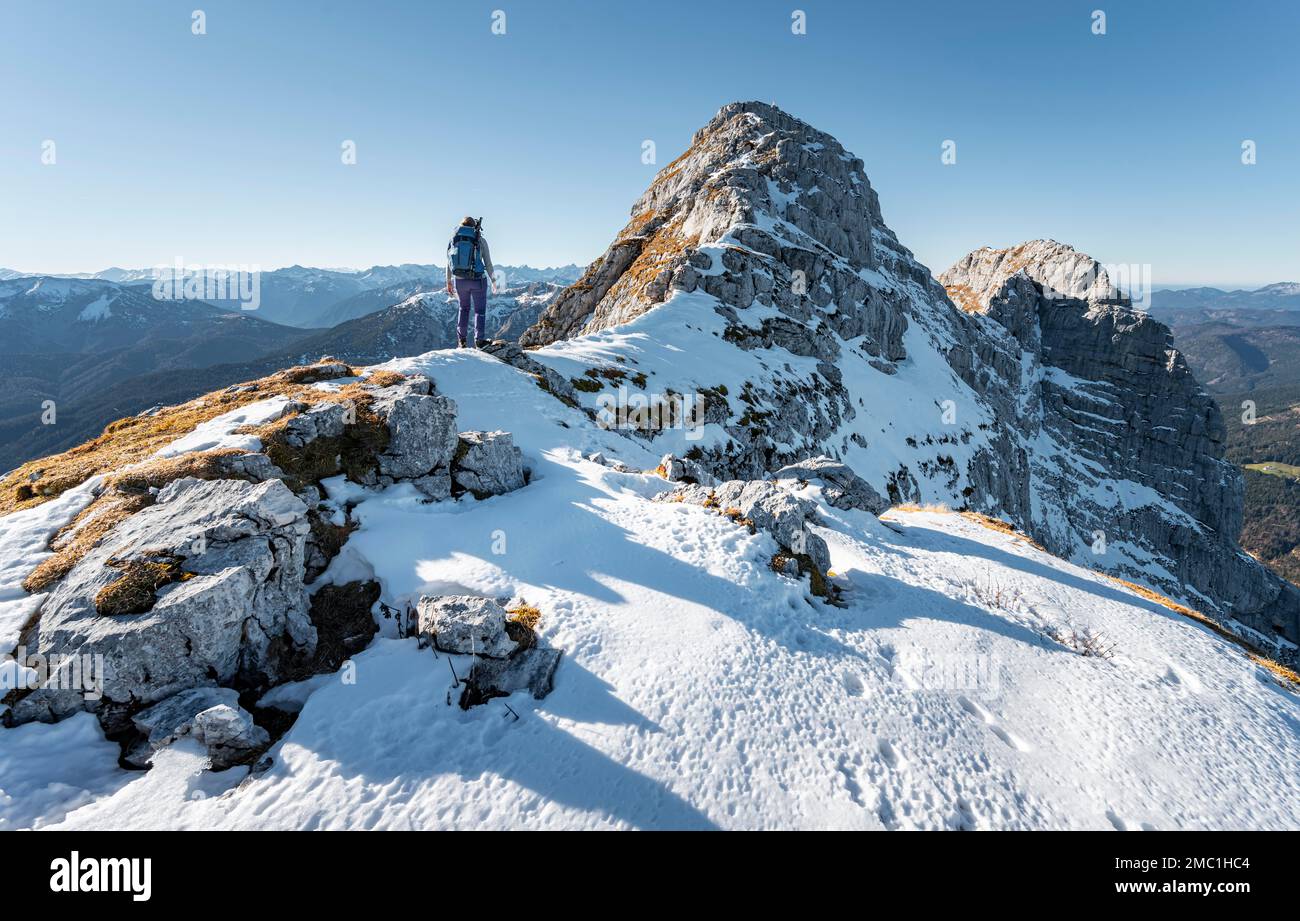 Mountaineer looking over snow-covered mountains, mountain ridge, hiking ...
