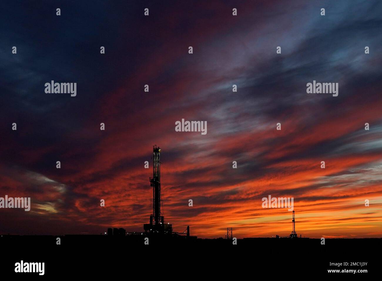 Oil drilling rigs are pictured at sunset, Monday, March 7, 2022, in El ...