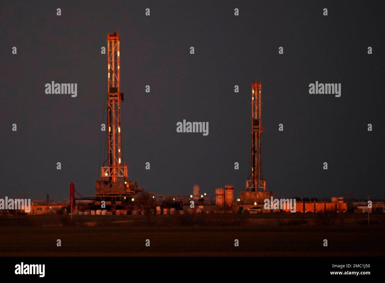 Oil drilling rigs are pictured at dusk, Monday, March 7, 2022, in El ...