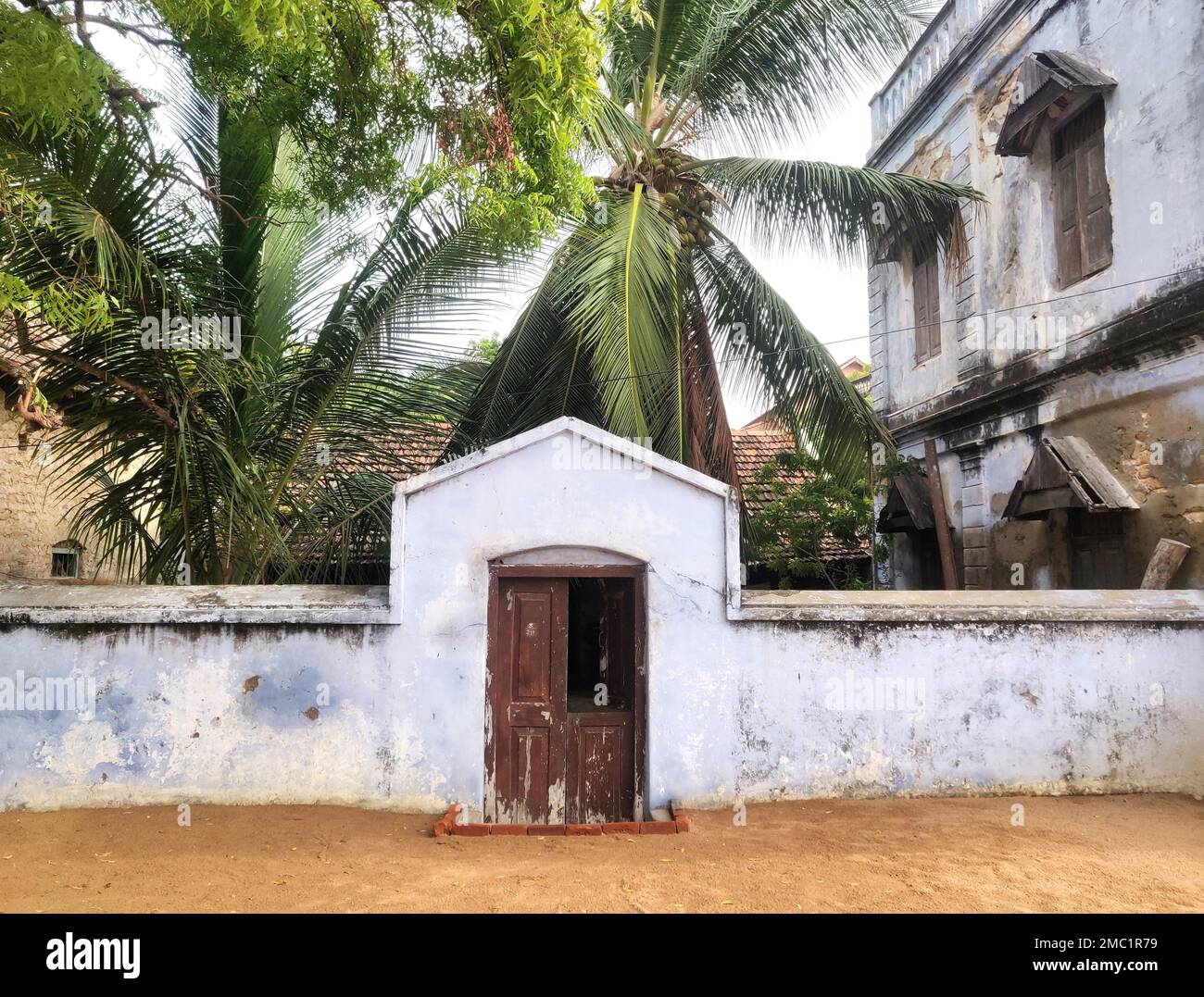 Security wall and rustic brown door, Manapad, Tamil Nadu Stock Photo ...