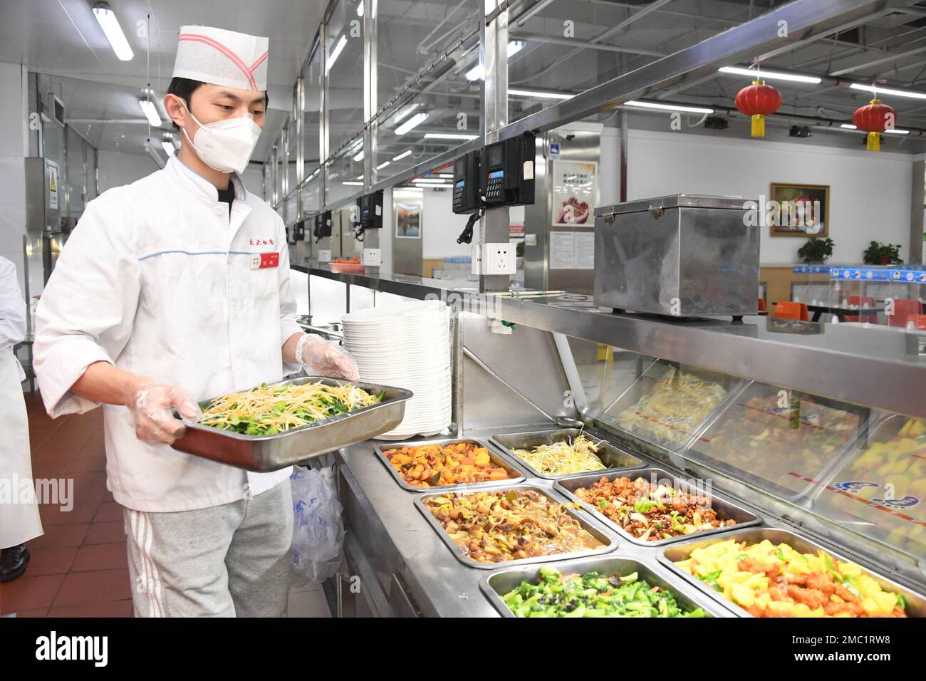 Beijing, China. 21st Jan, 2023. A staff member prepares dishes for ...
