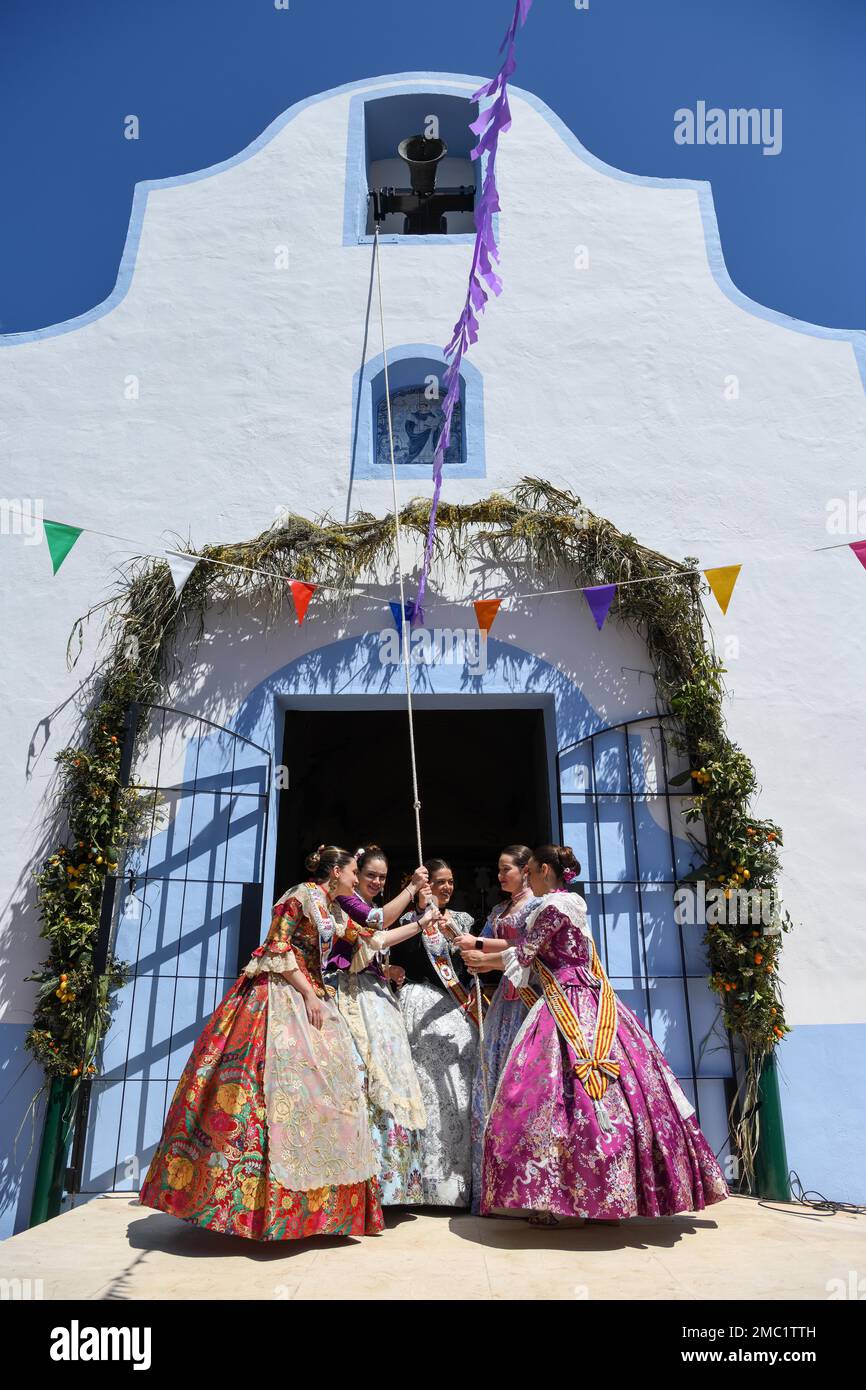 Young woman in traditional dress ring the bells of the Ermita de San ...