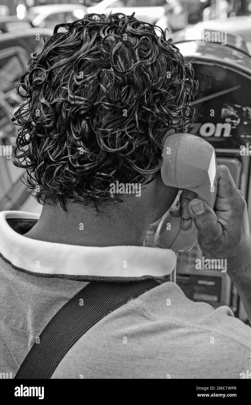 Black-haired New Yorker making a phone call at a telephone pillar, New ...