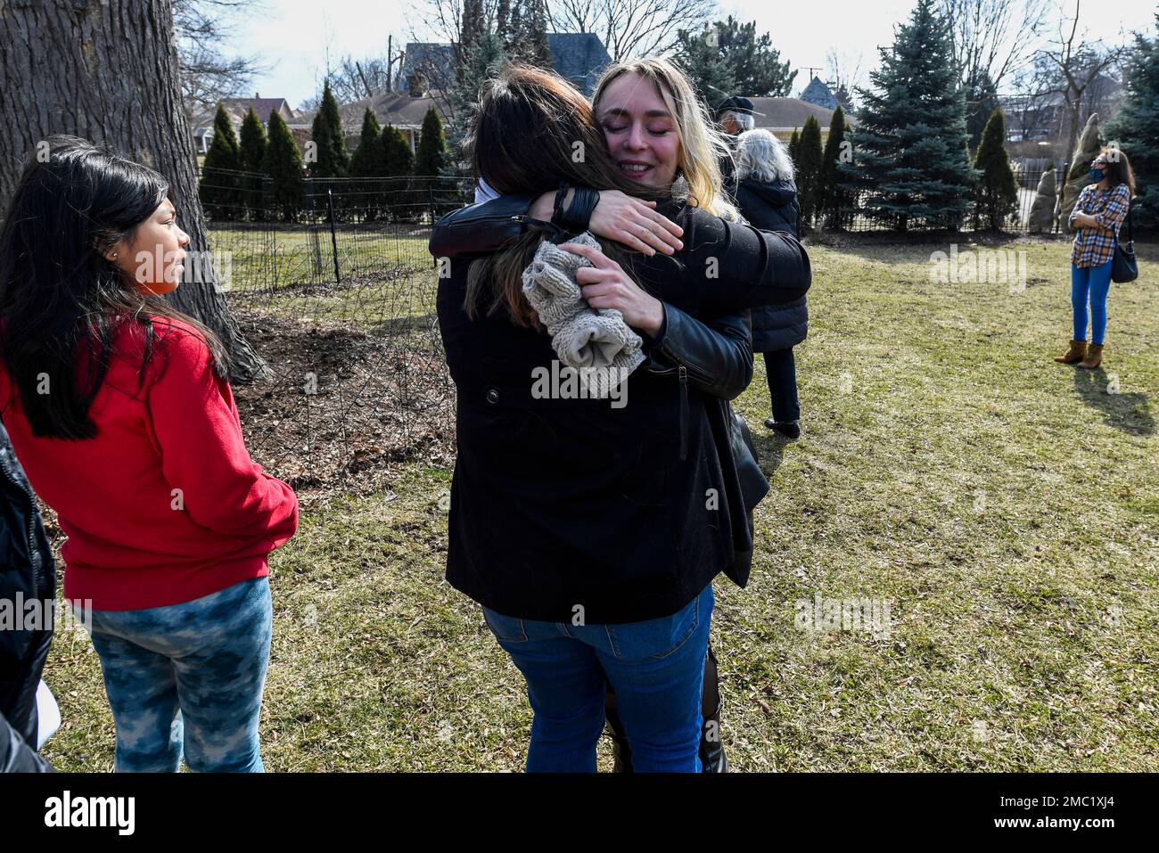 Newlywed Maria, facing camera, hugs a friend before she married her ...