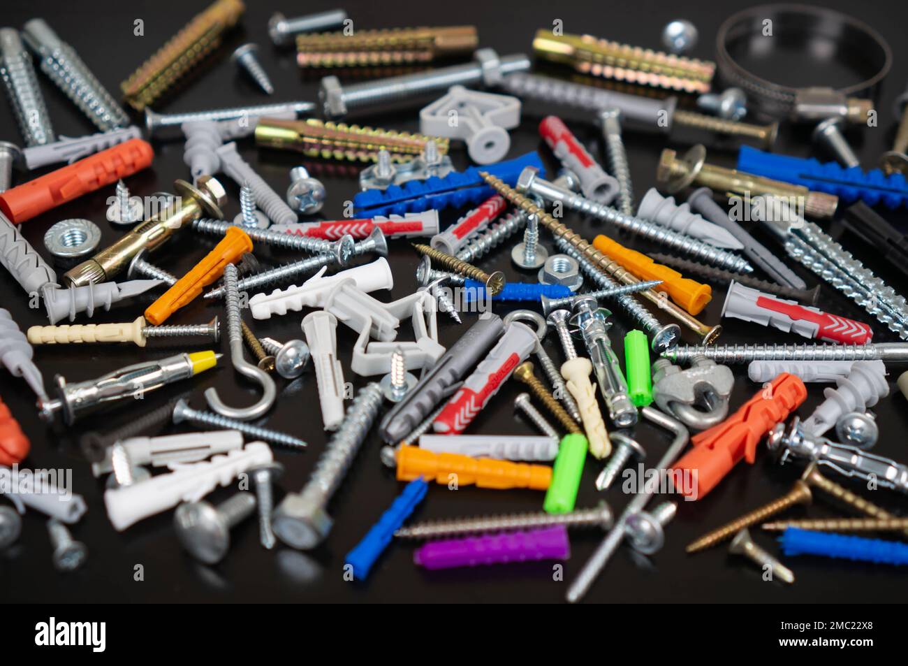 Different types of fasteners on a dark wood background. Front view ...