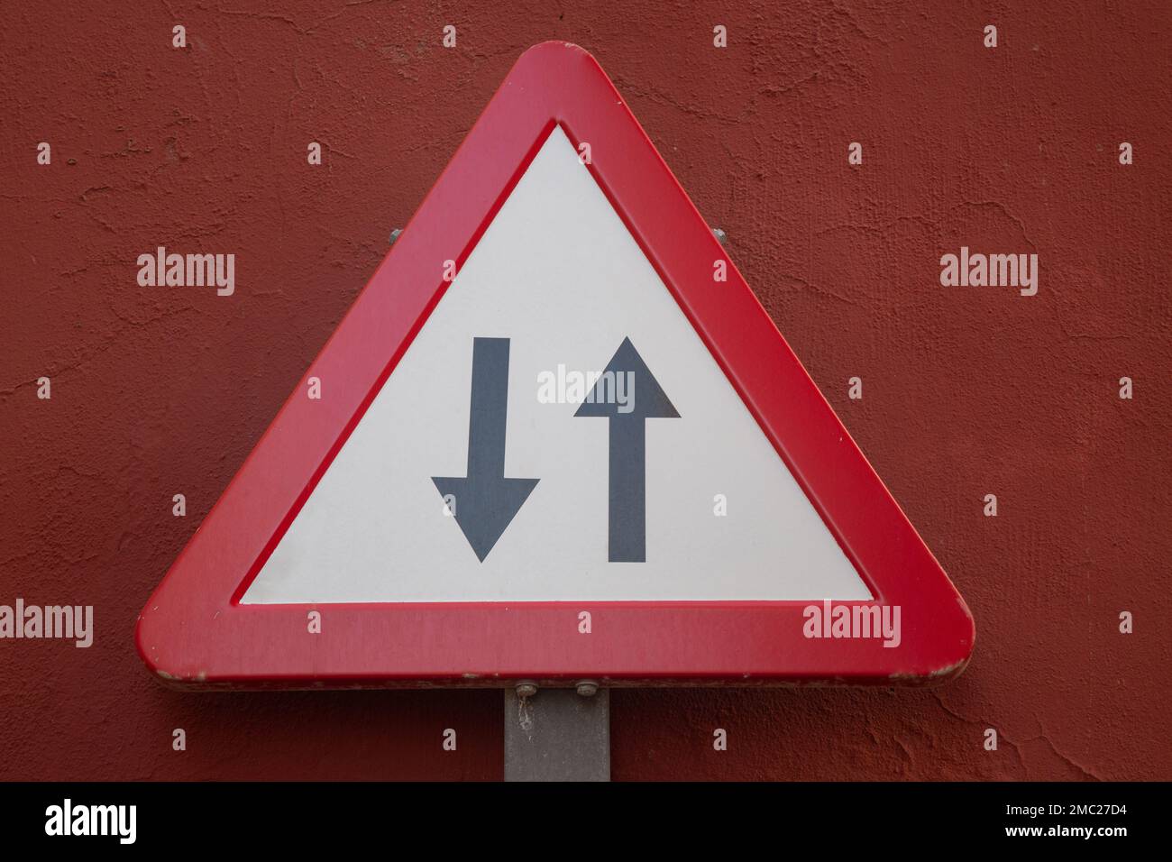 Two Way Traffic Sign on Red Wall Stock Photo - Alamy