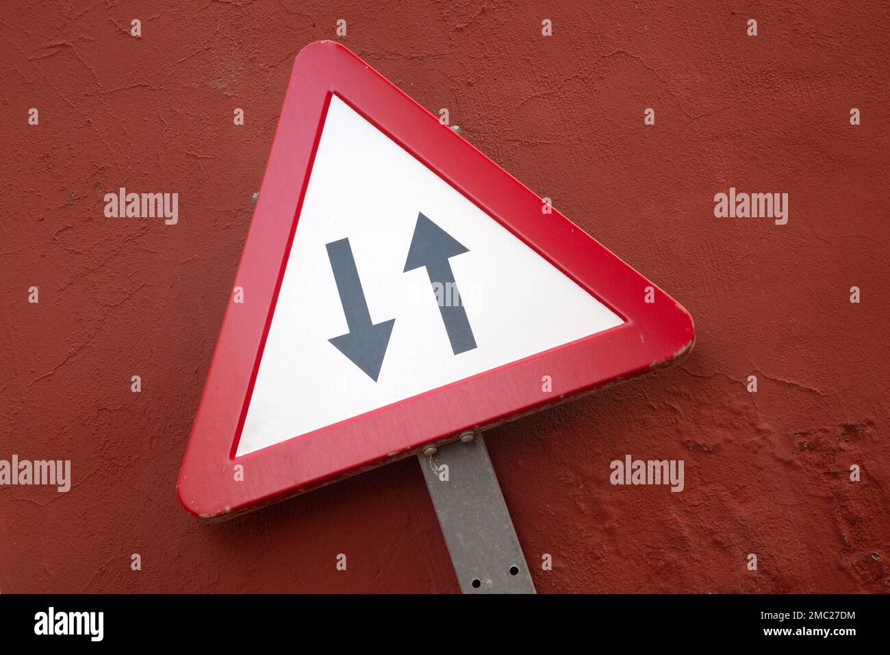Two Way Traffic Sign on Red Wall on Diagonal Tilt Stock Photo - Alamy