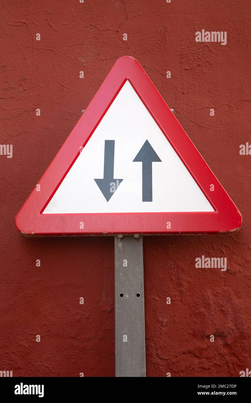 Two Way Traffic Sign on Red Wall Stock Photo - Alamy