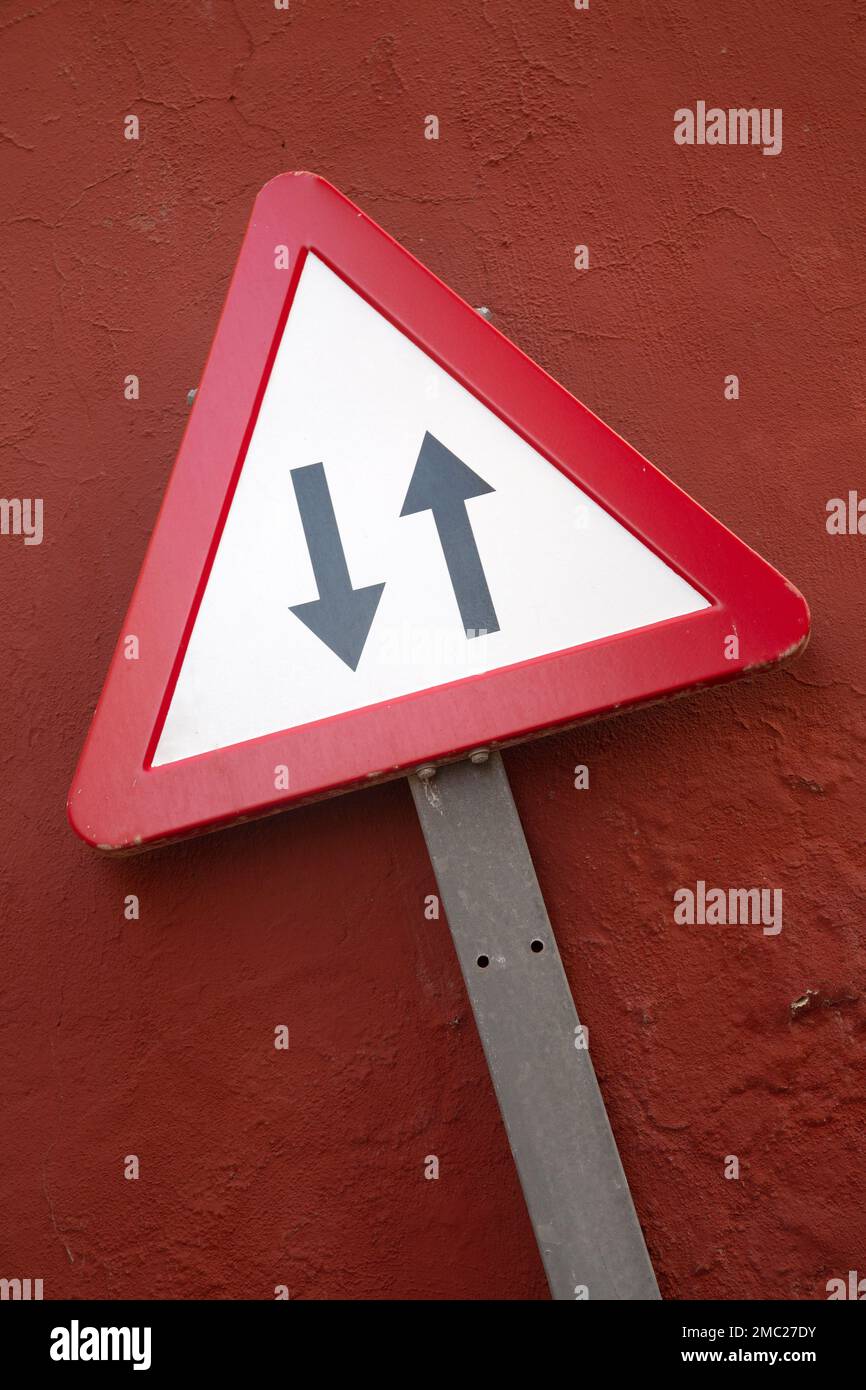 Two Way Traffic Sign on Red Wall on Diagonal Tilt Stock Photo - Alamy