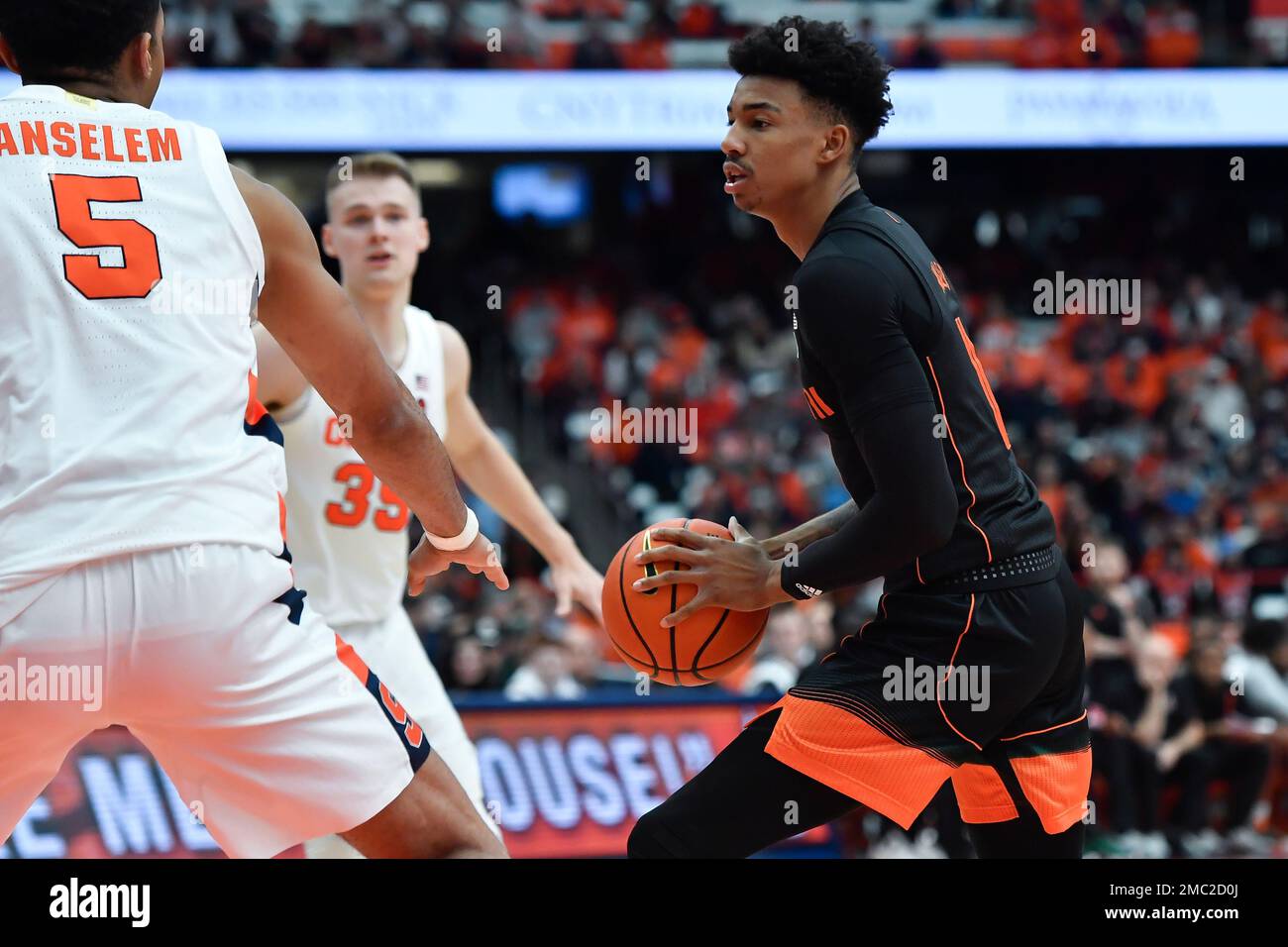 Miami guard Jordan Miller, right, looks to pass during the first half ...