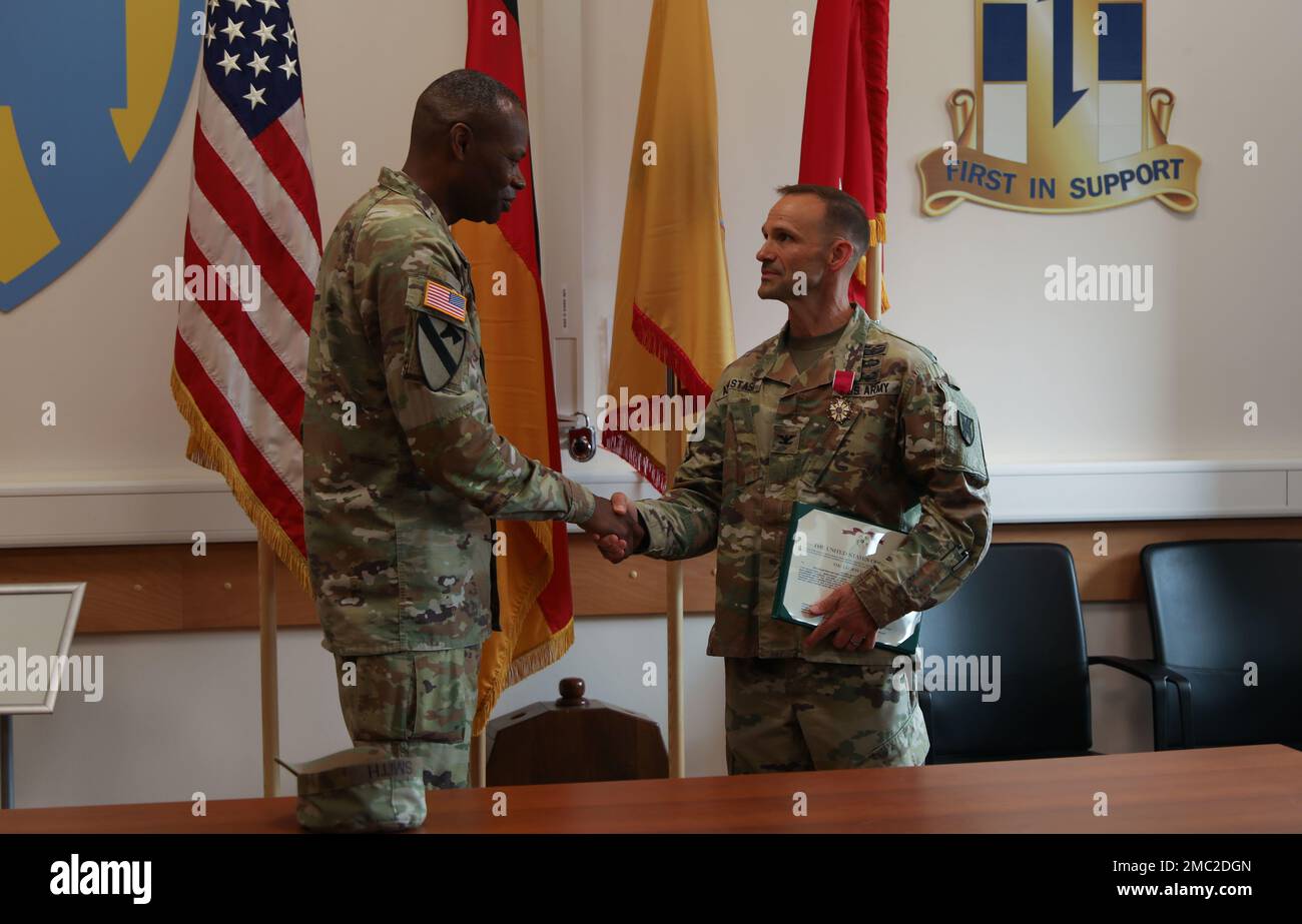 Maj. Gen. James Smith, commanding general, 21st Theater Sustainment Command, left, gives a coin ...