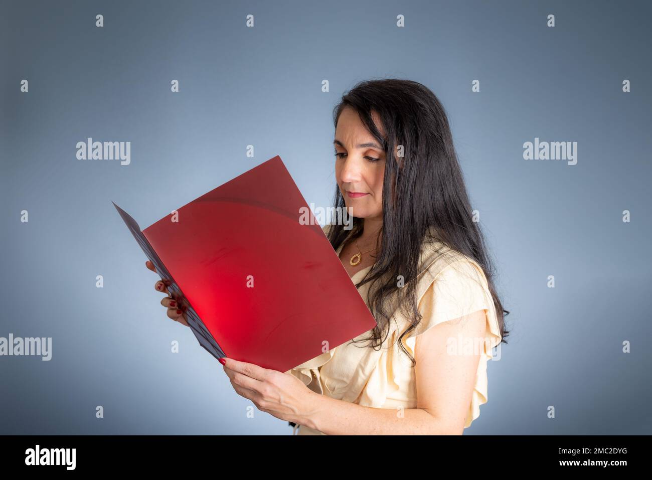 Portrait of professional female lawyer reading clients folder. Isolated ...