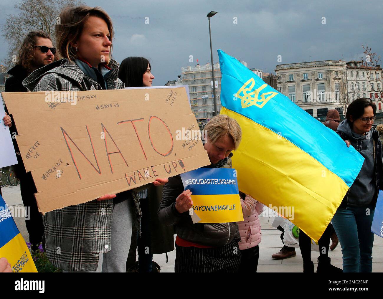 A Ukrainian woman holds a sign reading "Nato wake up" as another ...
