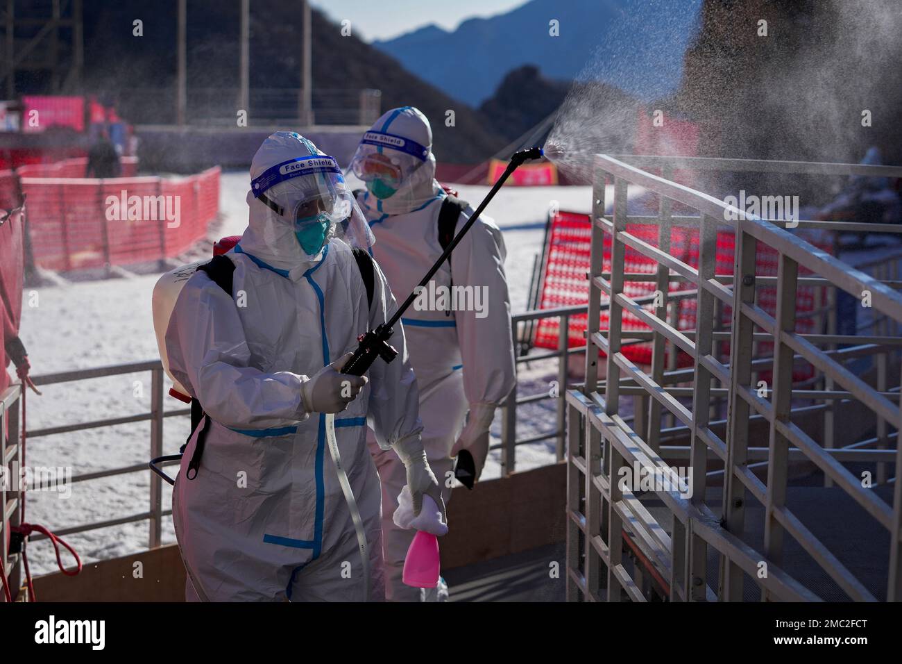 Health workers spray disinfectant on a passageway of the Alpine ...