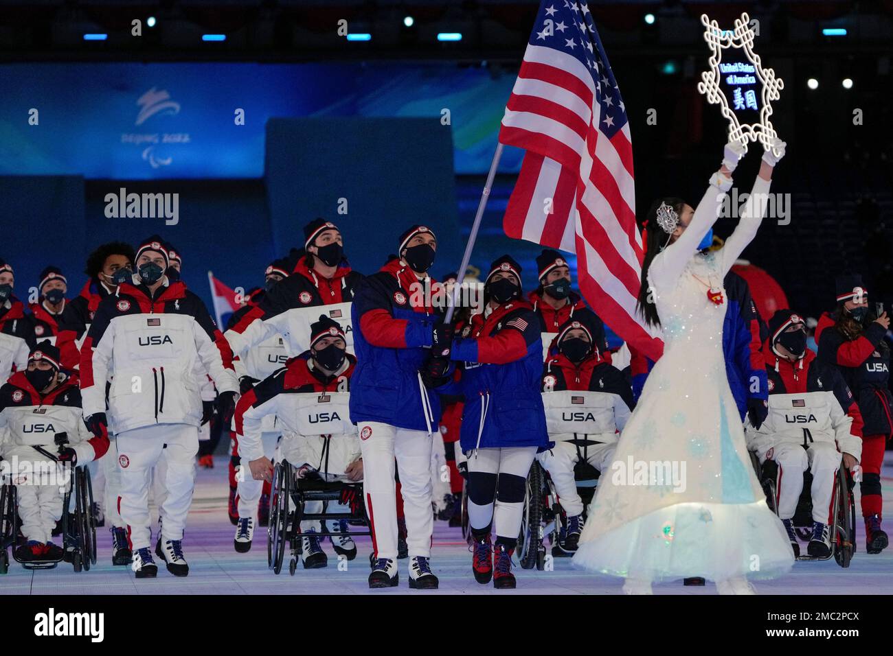 Danelle Umstead and Tyler Carter of the United States carry the flag as ...