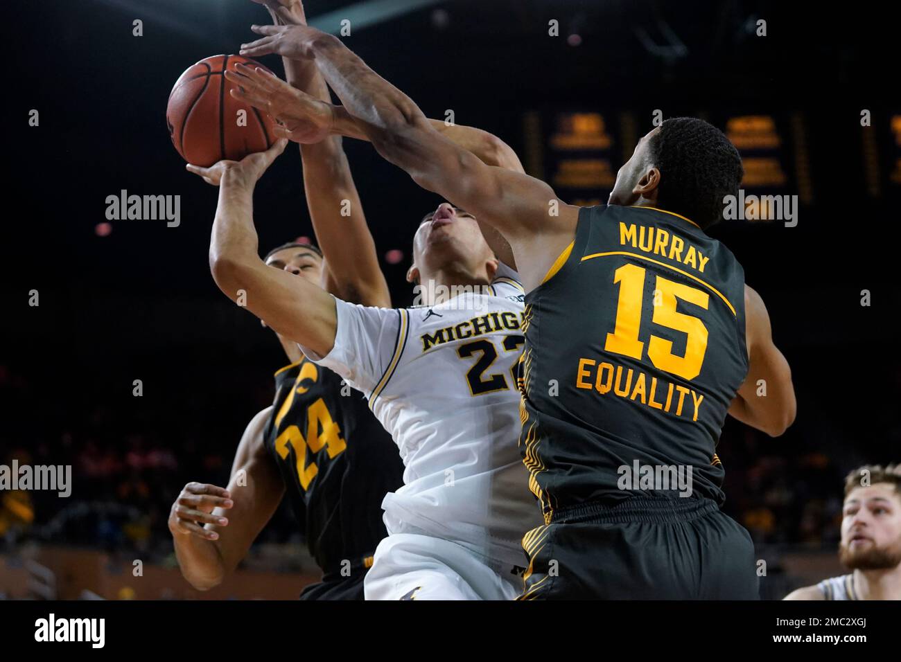 Michigan forward Caleb Houstan (22) drives between Iowa's Kris Murray ...