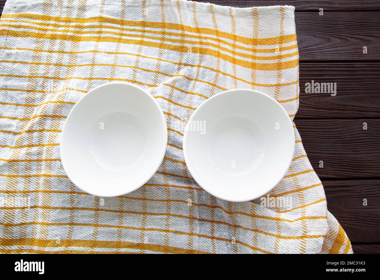 Empty plates on kitchen towel on wooden table, top view. Diet or ...