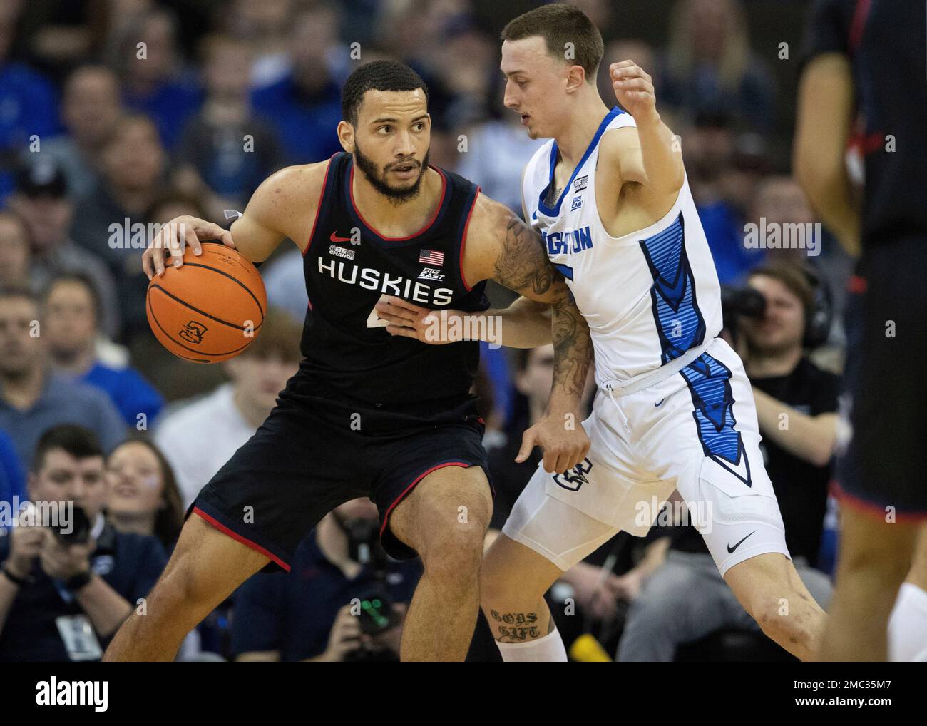 Connecticut's Tyrese Martin, left, is defended by Creighton's Alex O ...
