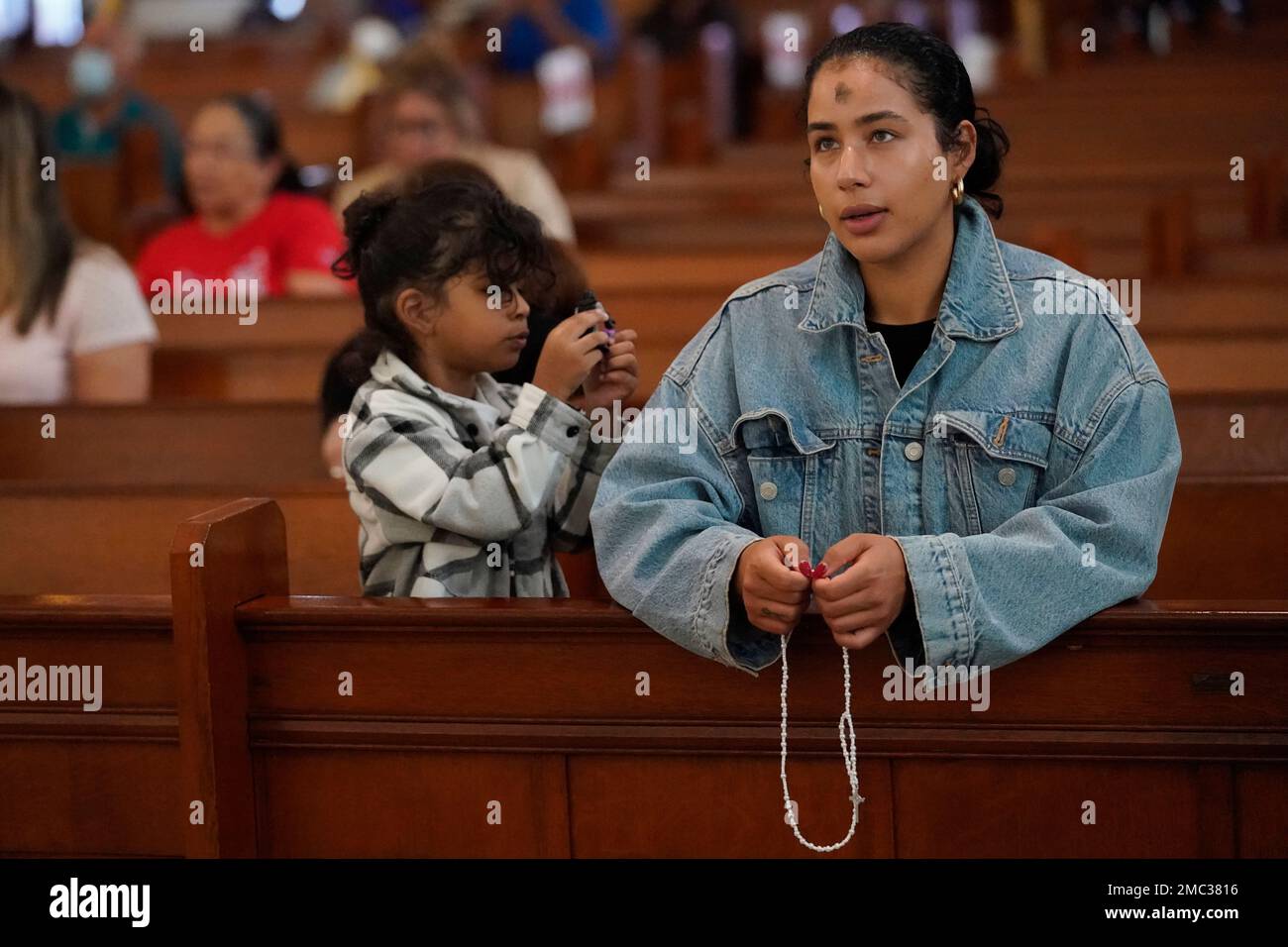 Francesca Hernandez prays as her son Leon Rodriguez, 4, plays with a ...