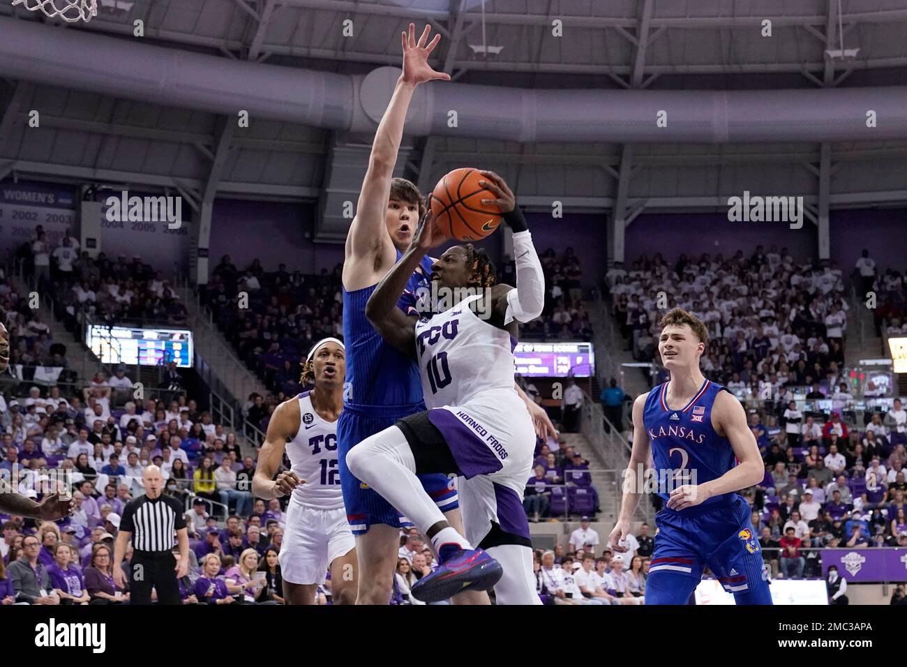 Kansas forward K.J. Adams, left, defends against a drive to the basket ...