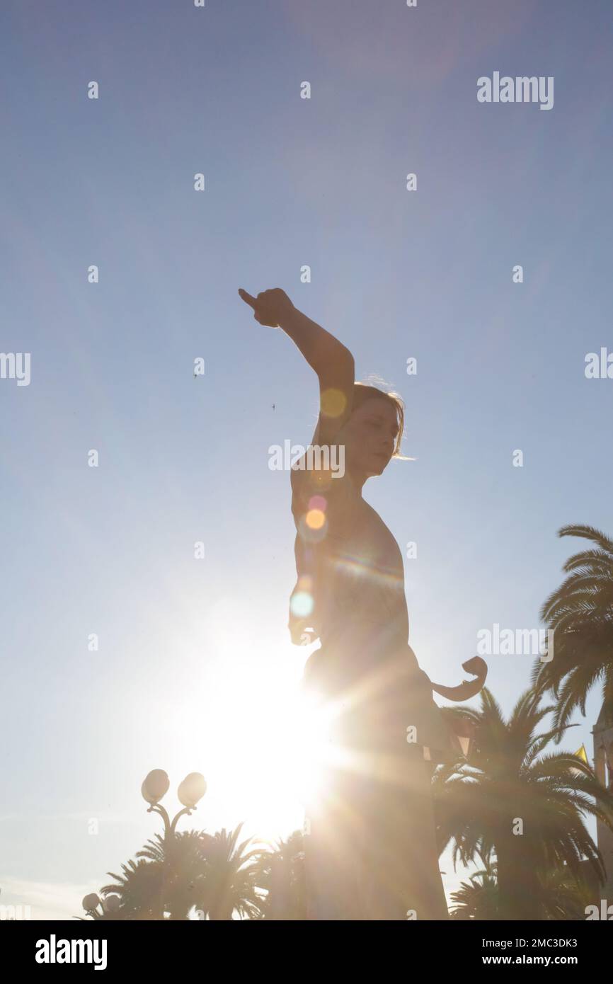 Beautiful young woman raising arms under blue sky, concept of freedom ...