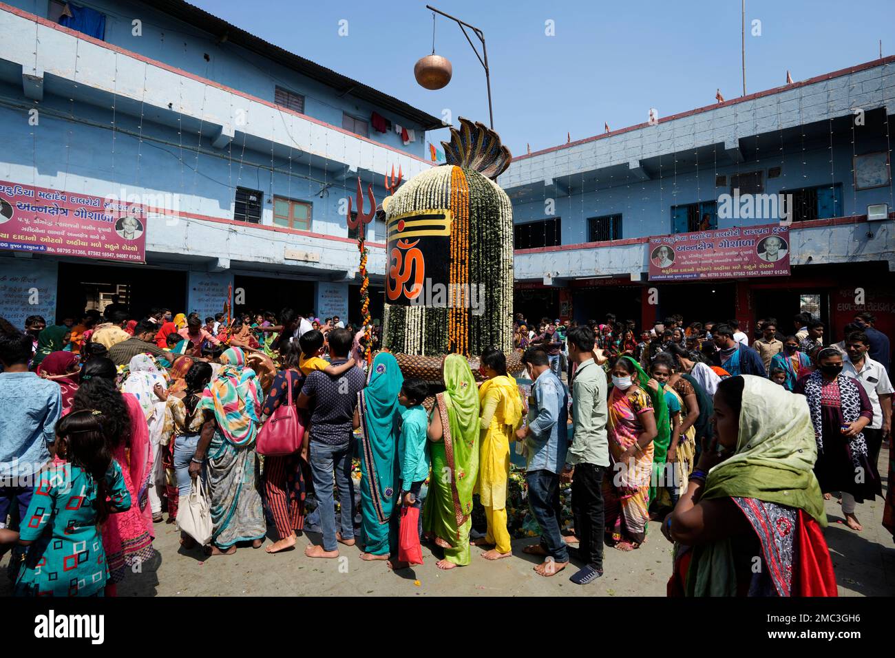 Hindu devotees perform rituals around a Shivling, a representation of ...
