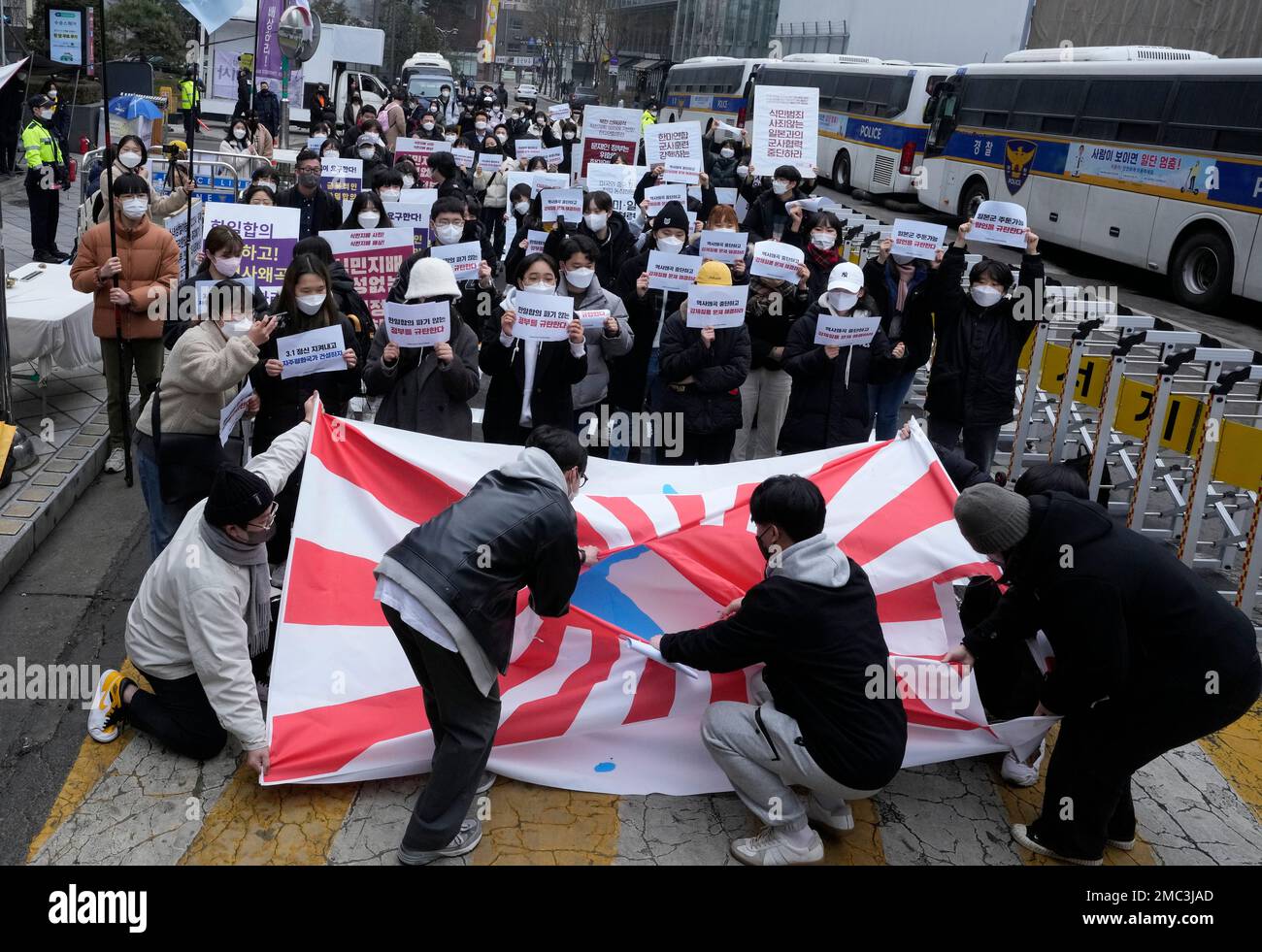 Protesters tear a Japanese rising sun flag during a rally to celebrate ...