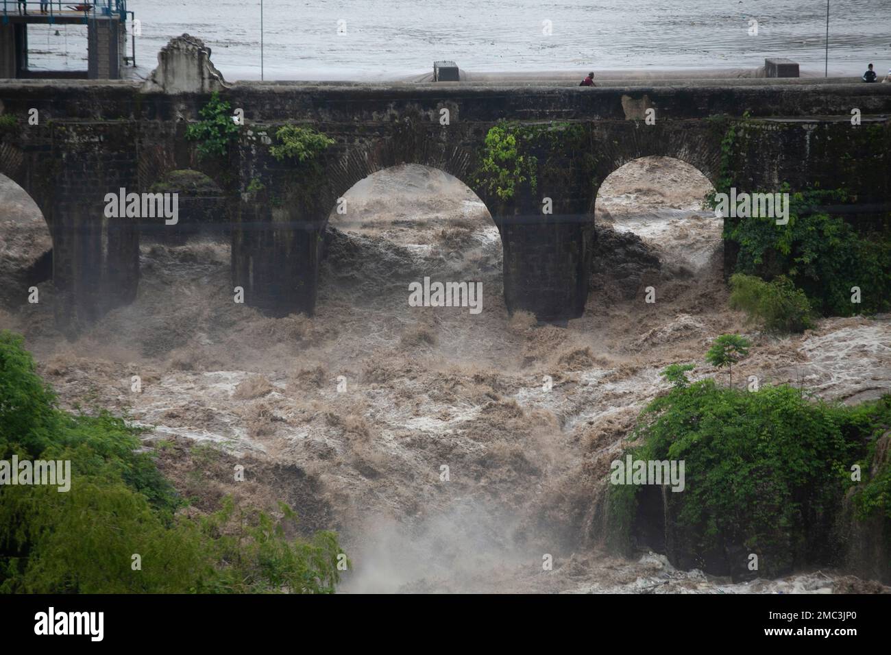 FILE - The swollen Los Esclavos River flows violently under a bridge ...