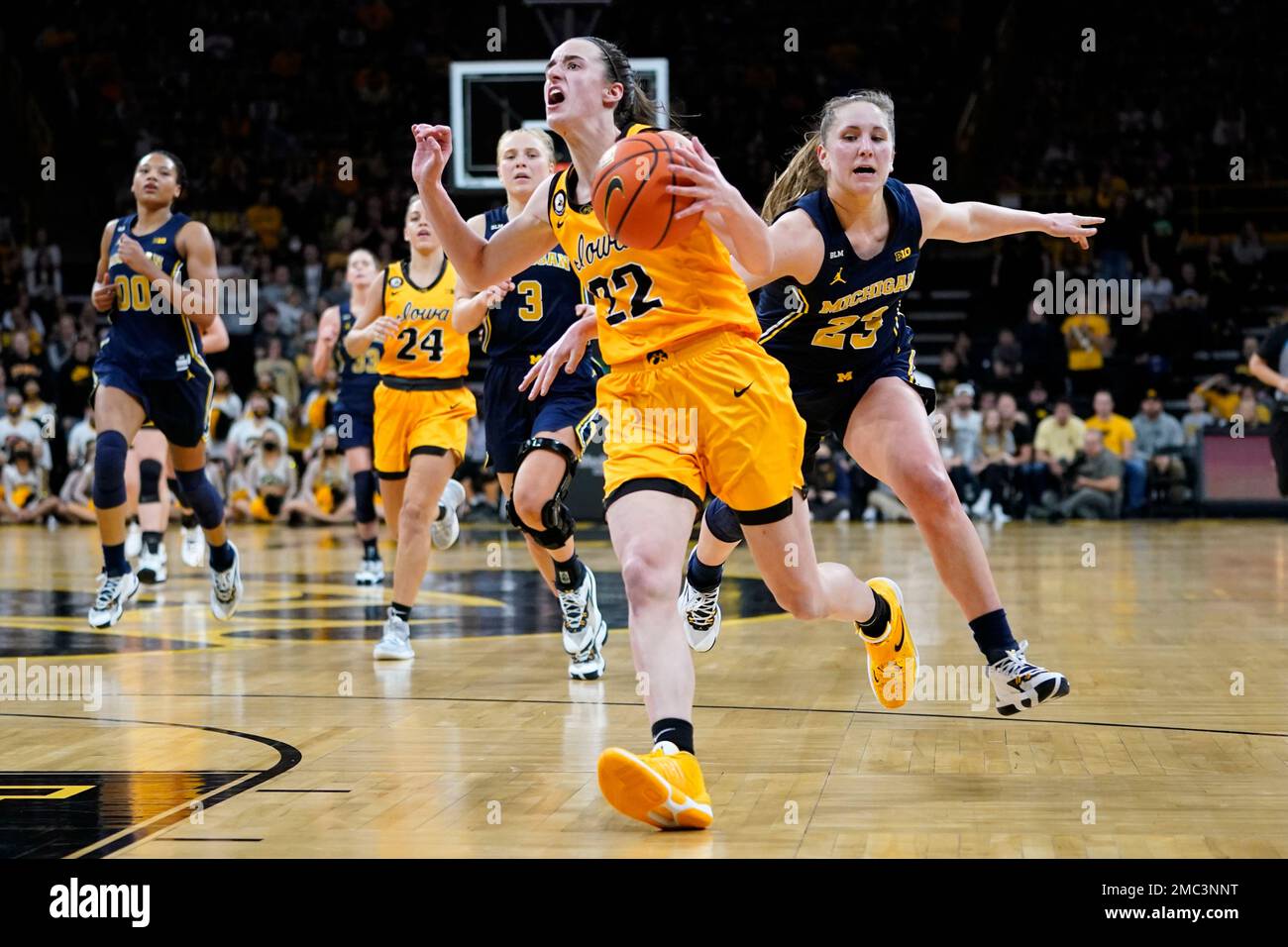 Iowa guard Caitlin Clark (22) drives up court ahead of Michigan guard ...