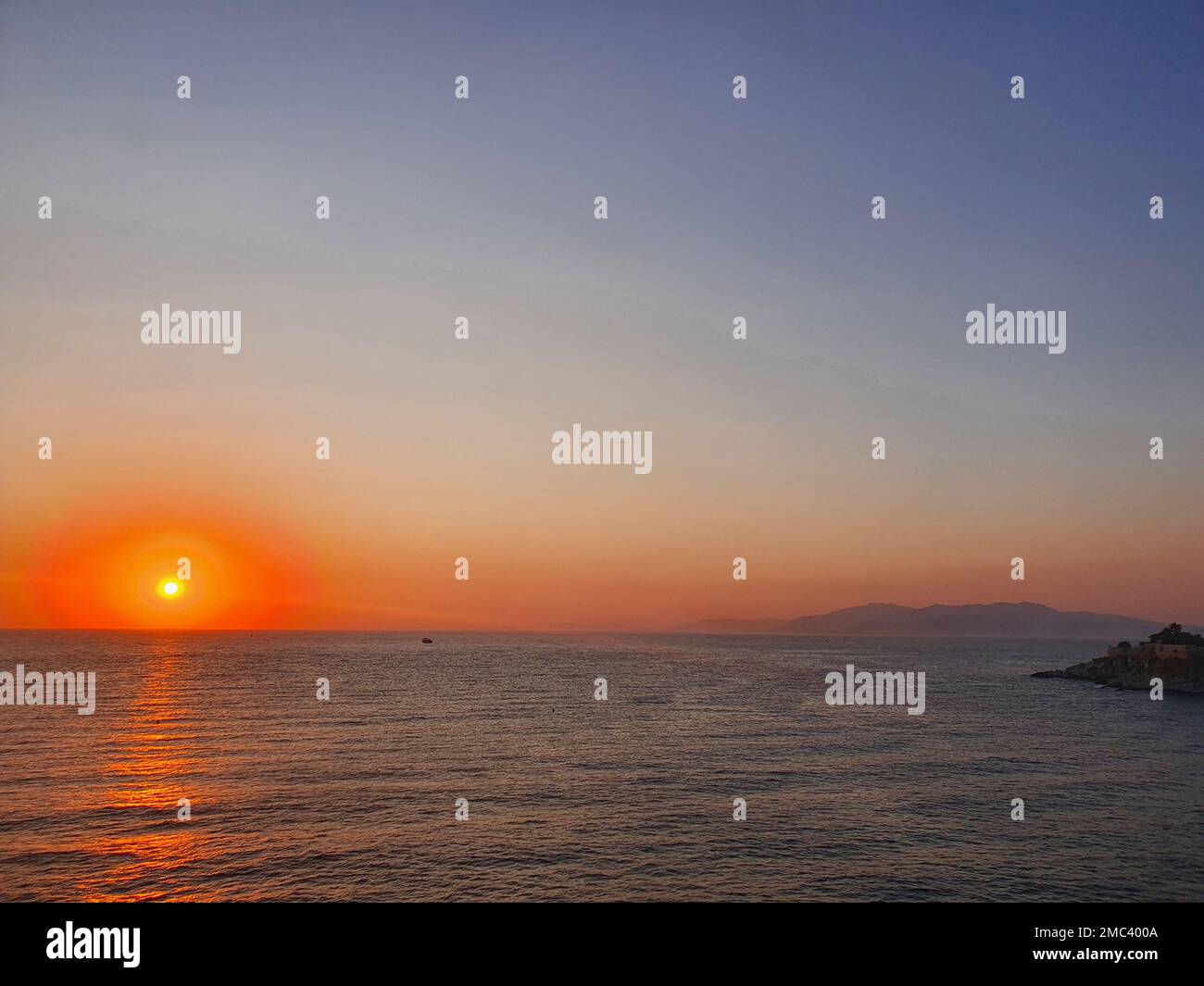 A beautiful sunset scene at a sea with the water reflecting the ...