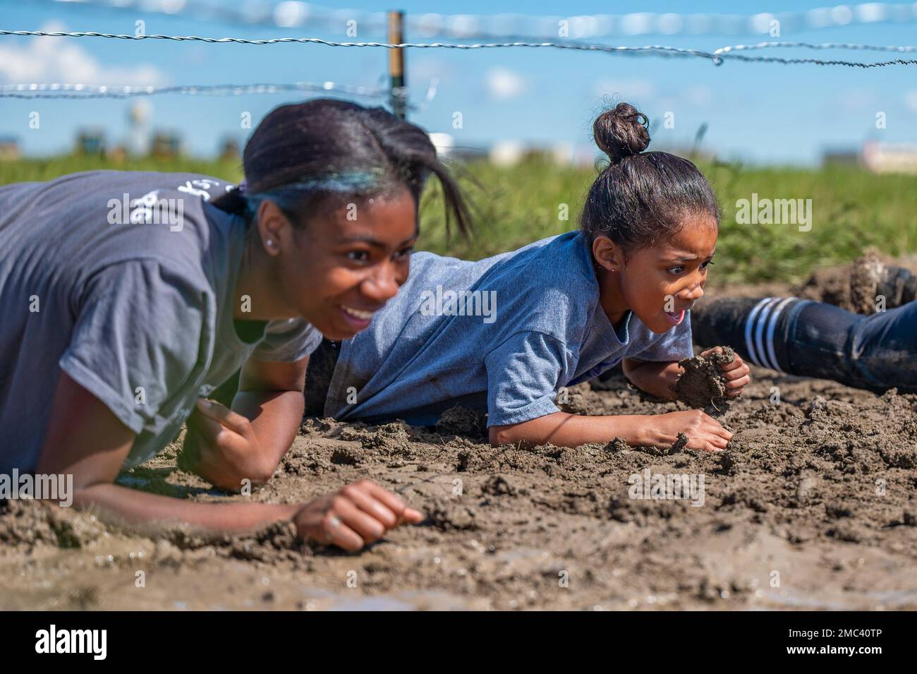 Community members crawl through a mud-ridden obstacle during the Filthy ...