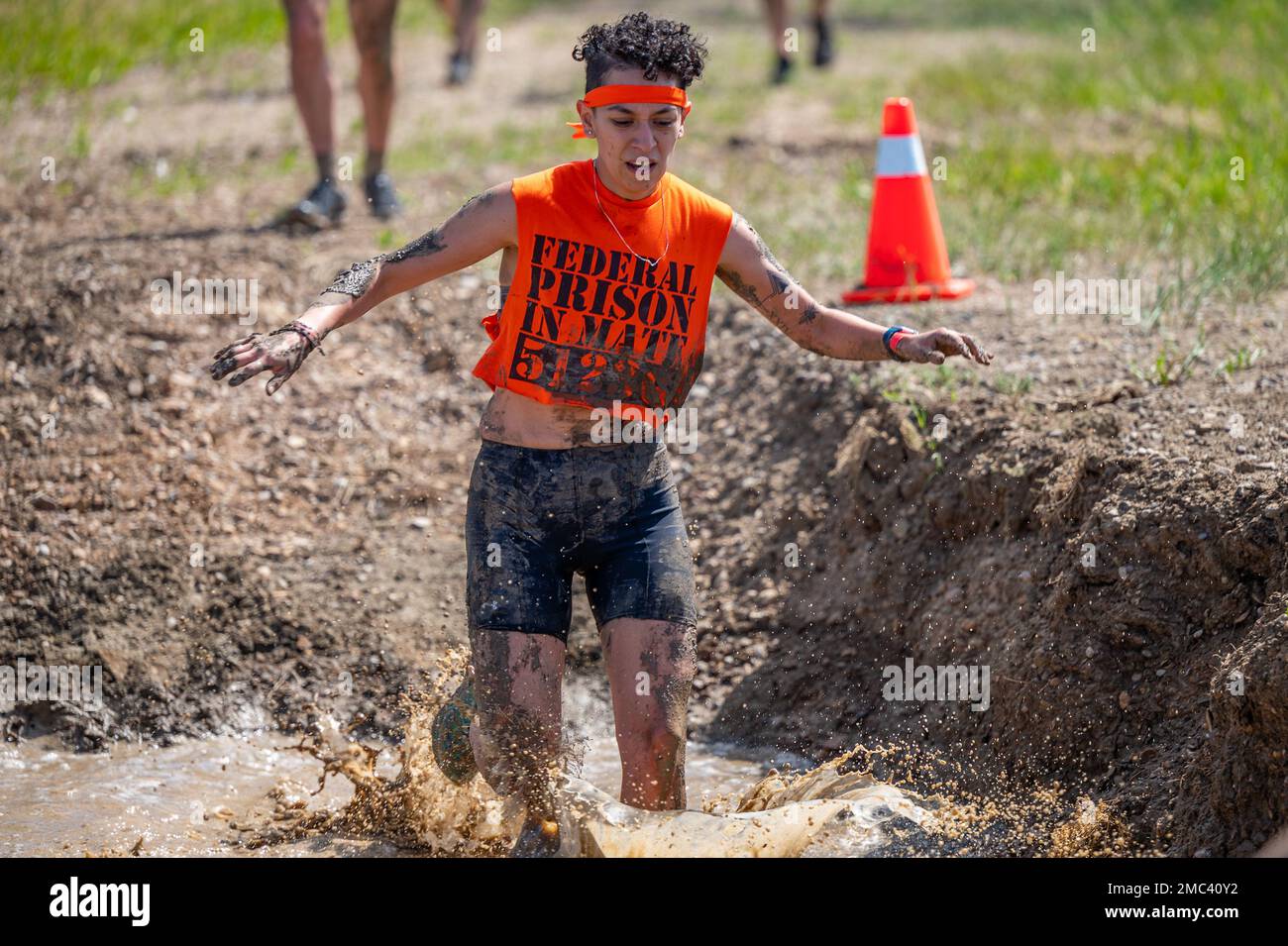 A competitor runs through a mud pit during the Filthy Mudder Mud Run ...