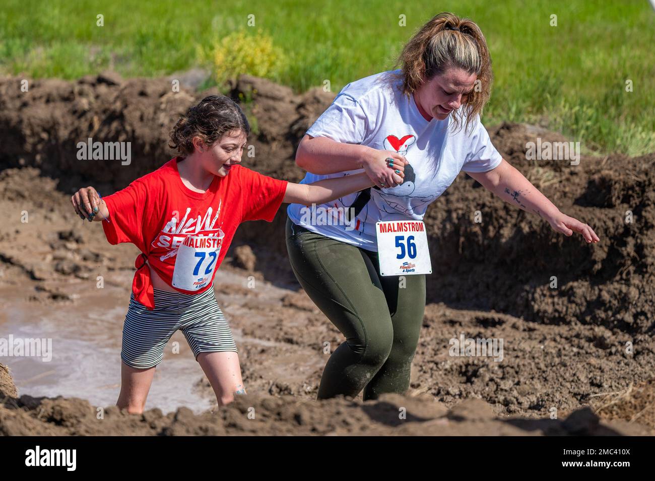 Community members help one another through a mud pit during the Filthy ...