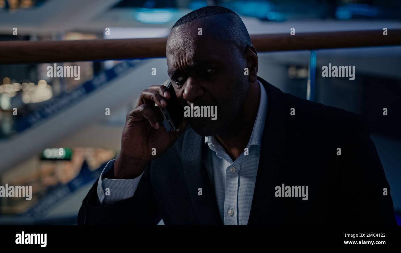 Pensive senior ethnic businessman sad answer call displeased talking ...