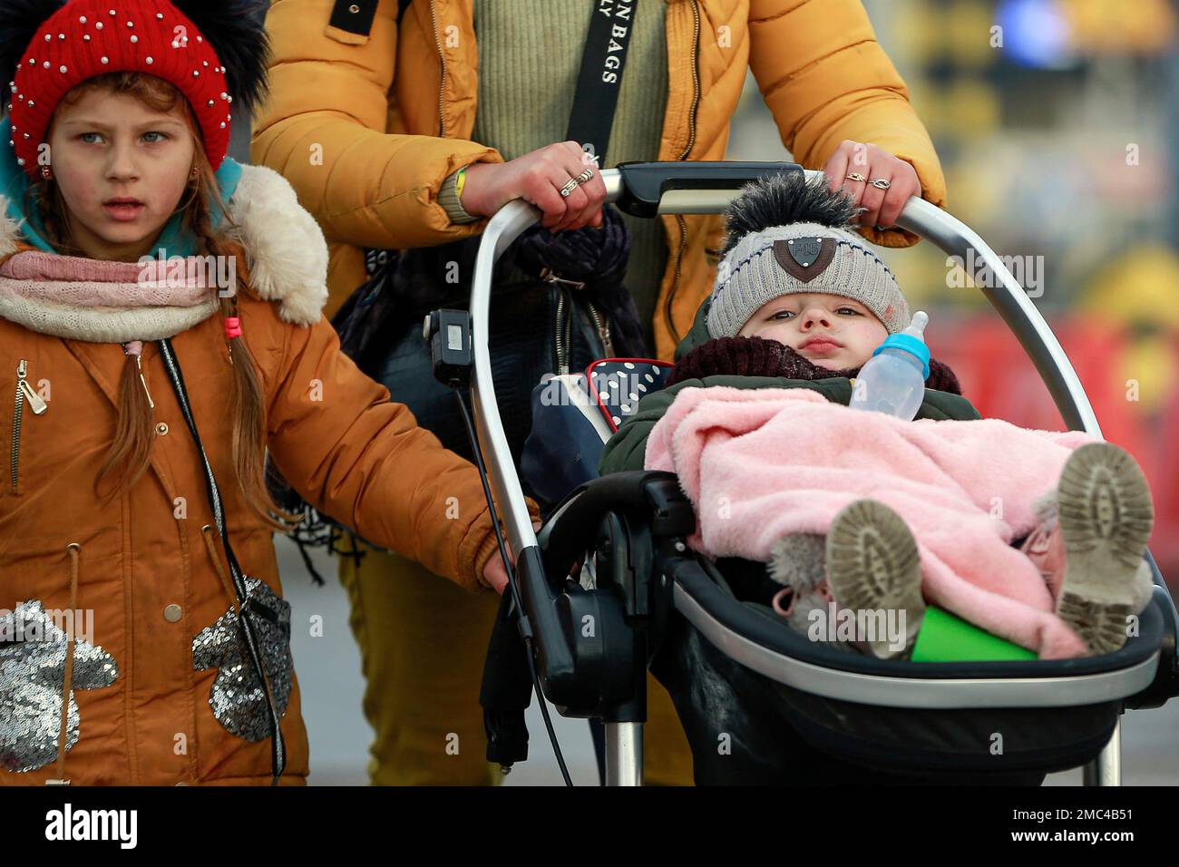 A Ukrainian refugee pushes her baby in a pushchair as they arrive at ...