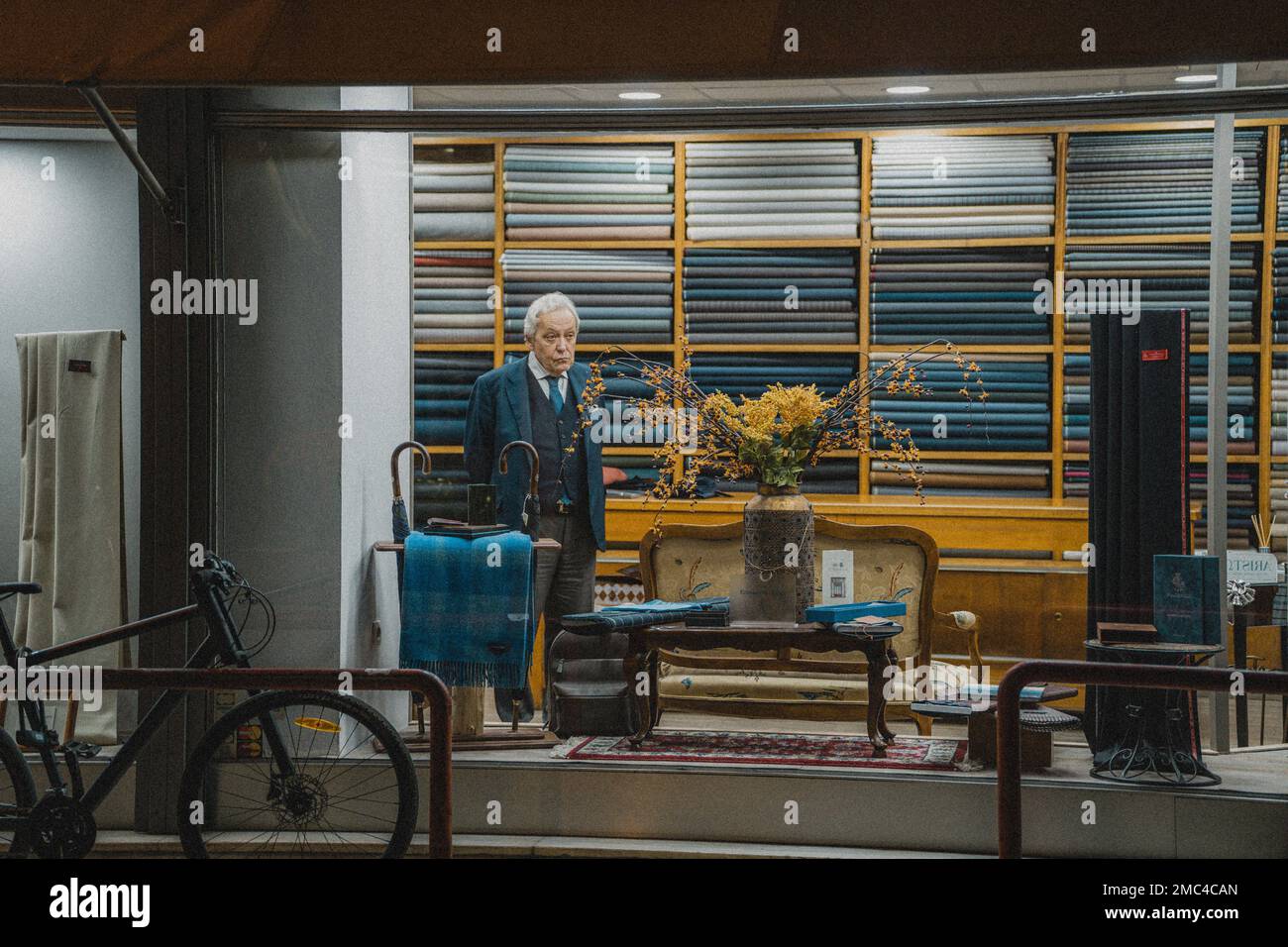 A shop owner gazing alone inside his store Stock Photo - Alamy