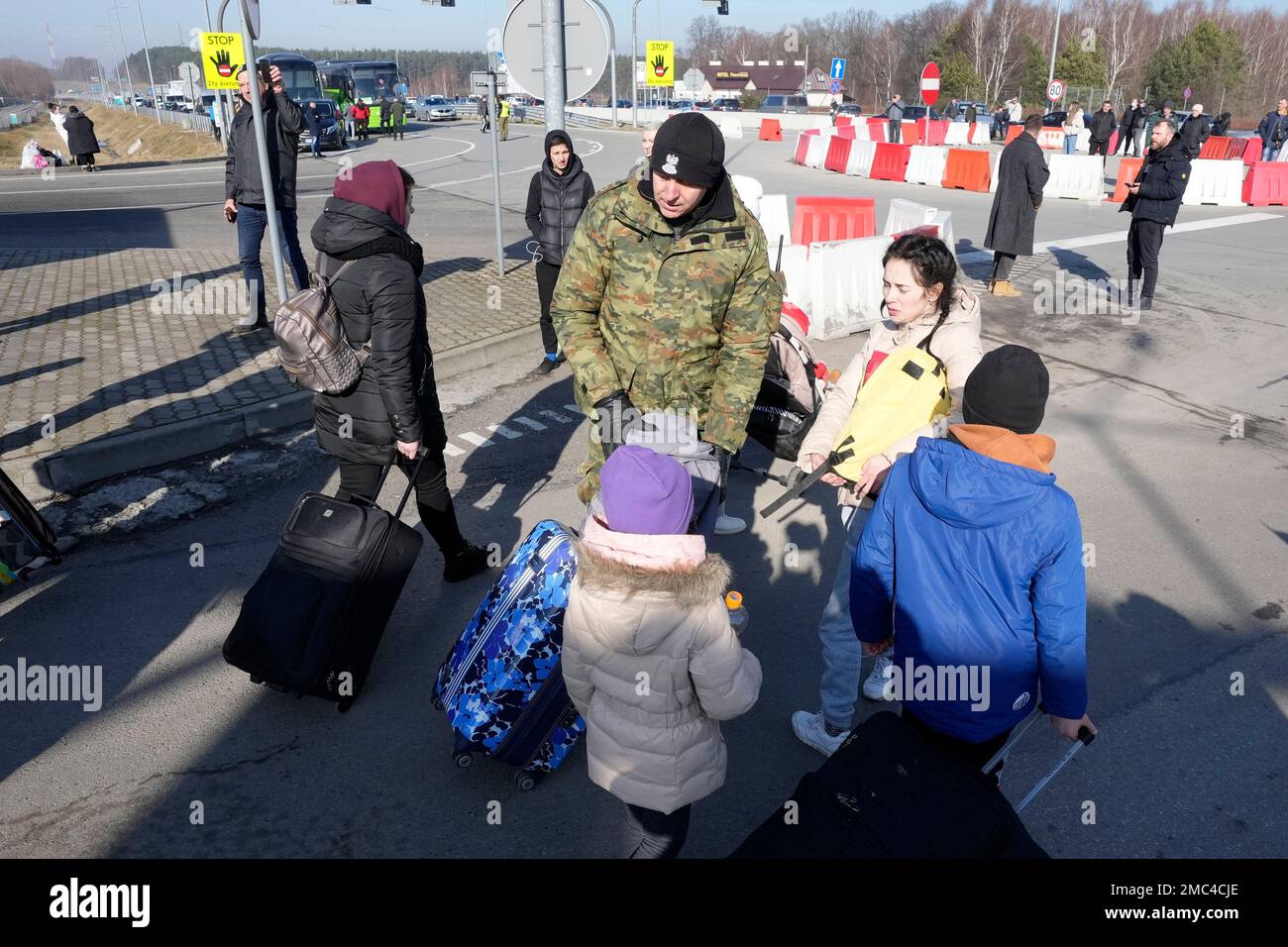 A Polish border guard assists refugees from Ukraine as they arrive to ...