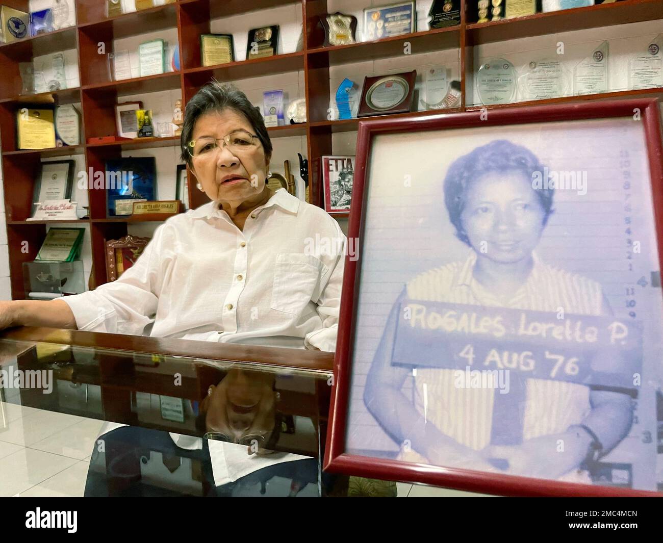 Human rights activist Loretta Rosales sits behind a photo, a grainy ...