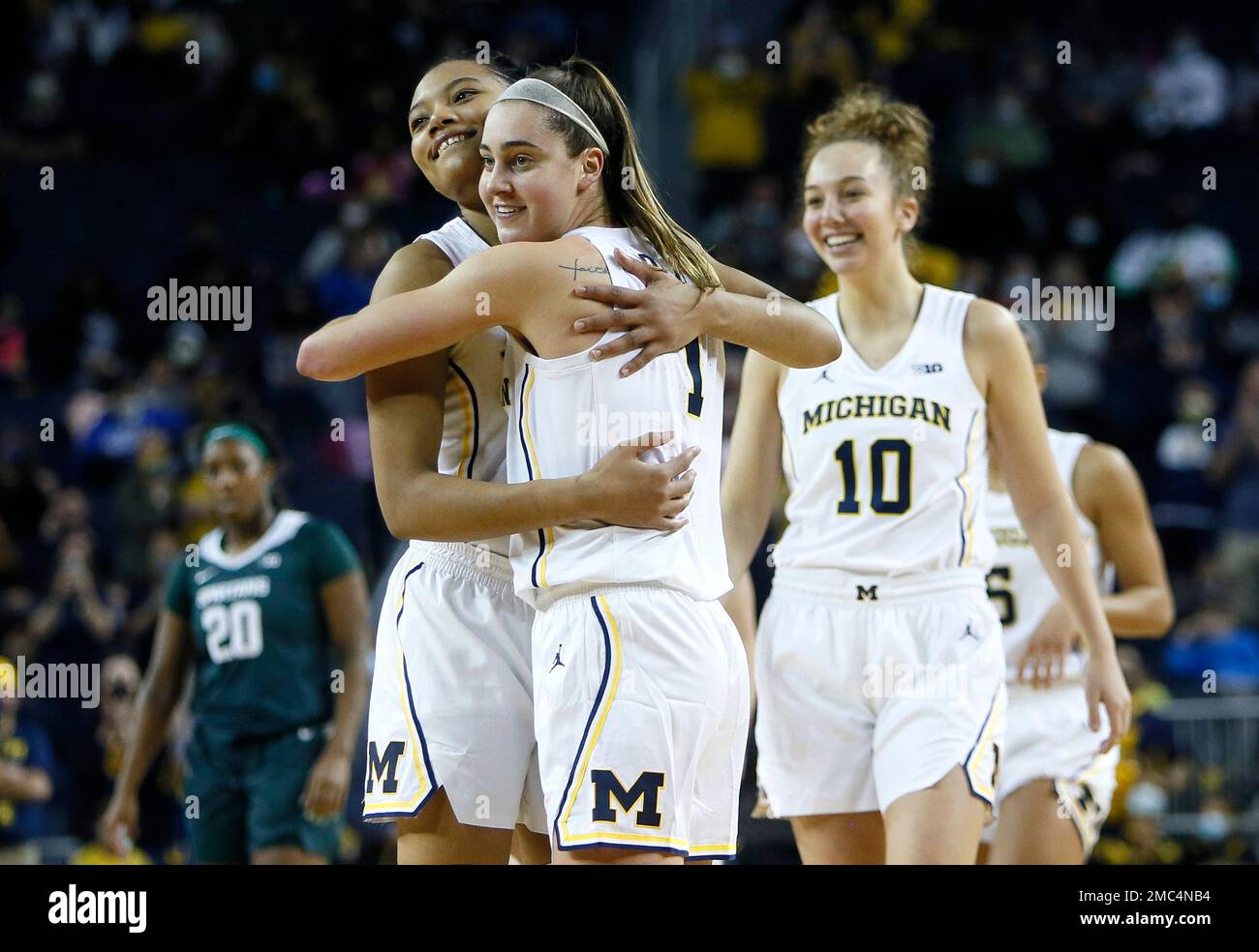 Michigan forward Naz Hillmon, left, hugs guard Amy Dilk (1), next to ...