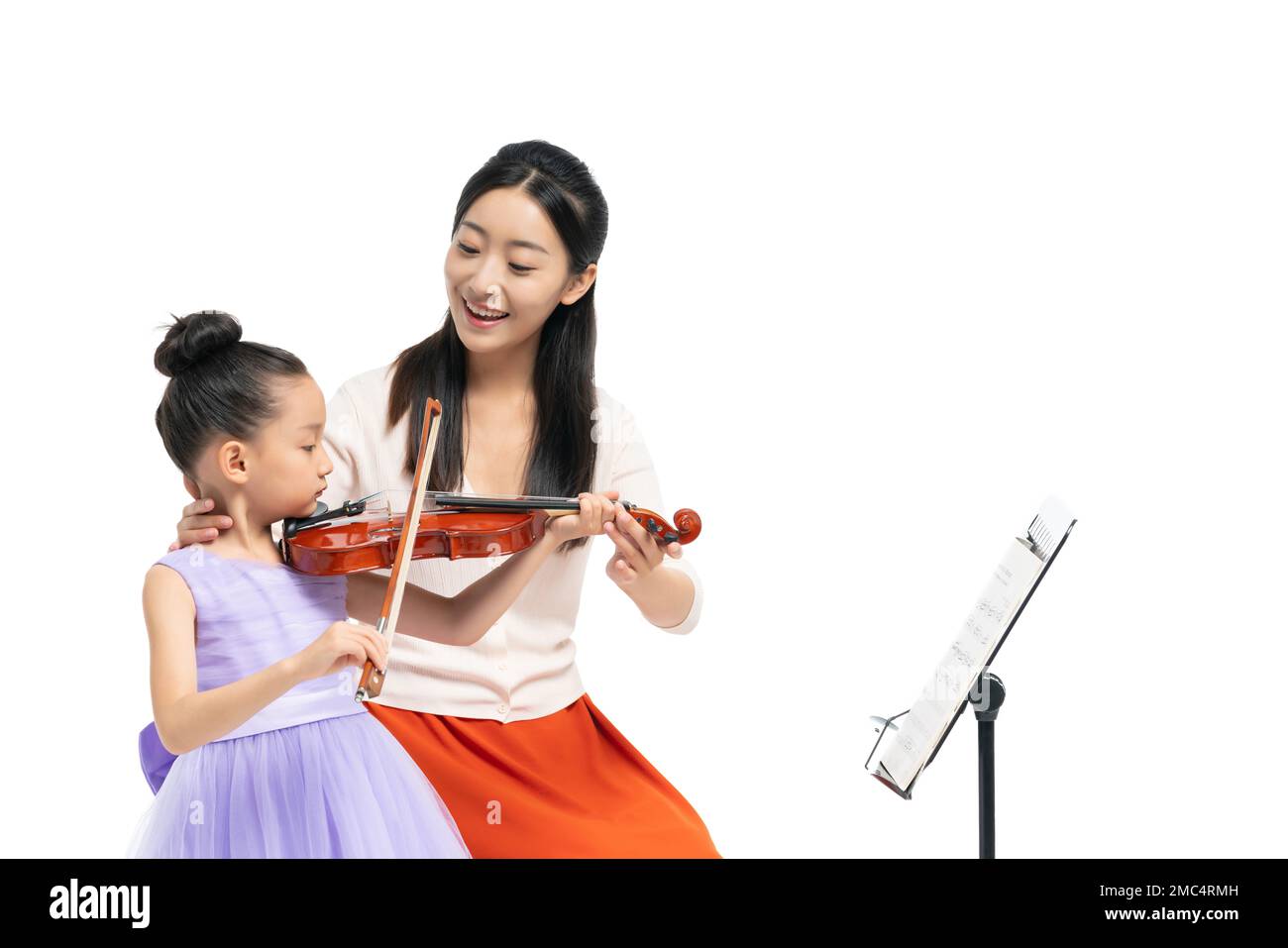 The female teacher guide girl playing Musical Instruments Stock Photo ...