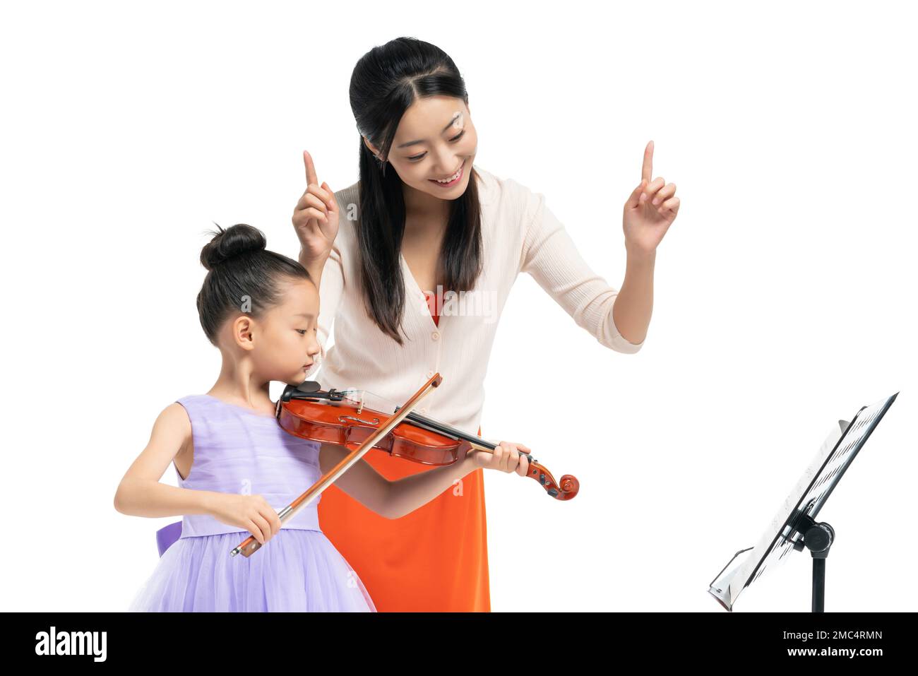 The female teacher guide girl playing Musical Instruments Stock Photo ...