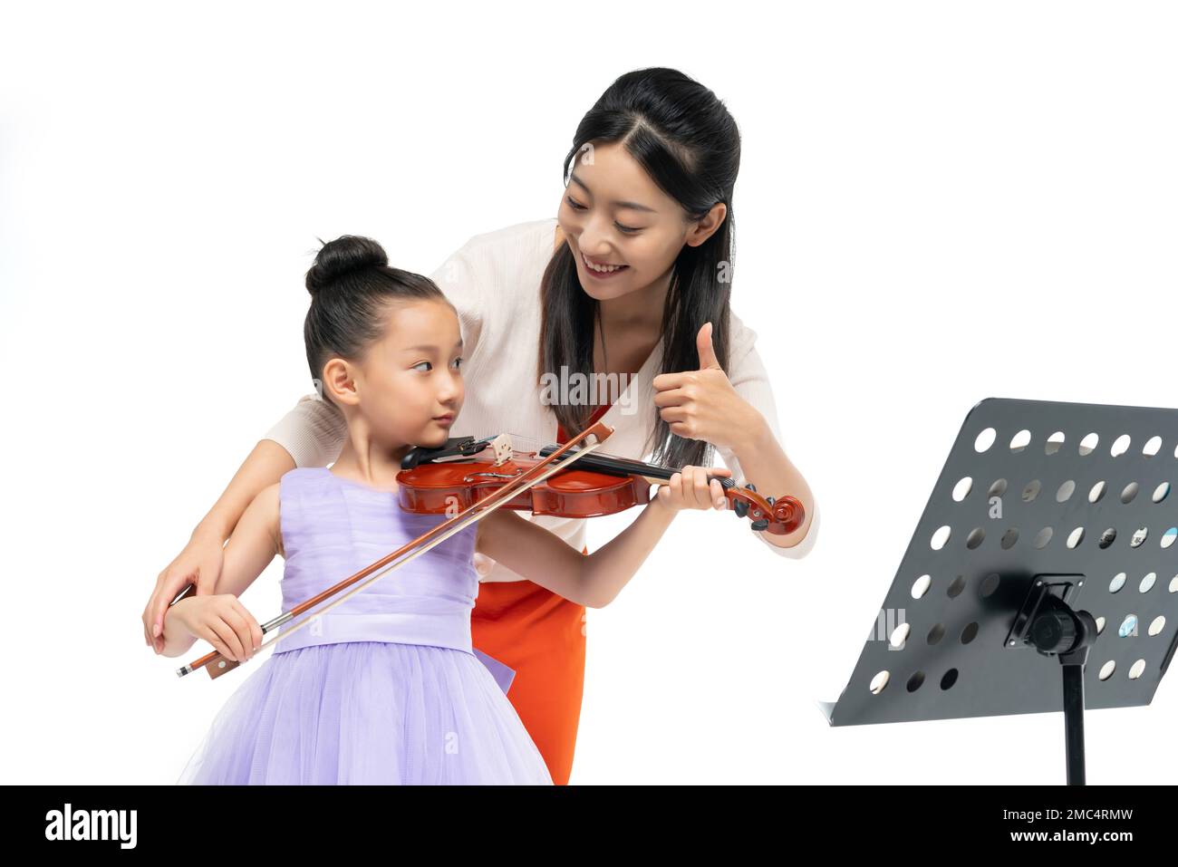 The female teacher guide girl playing Musical Instruments Stock Photo ...