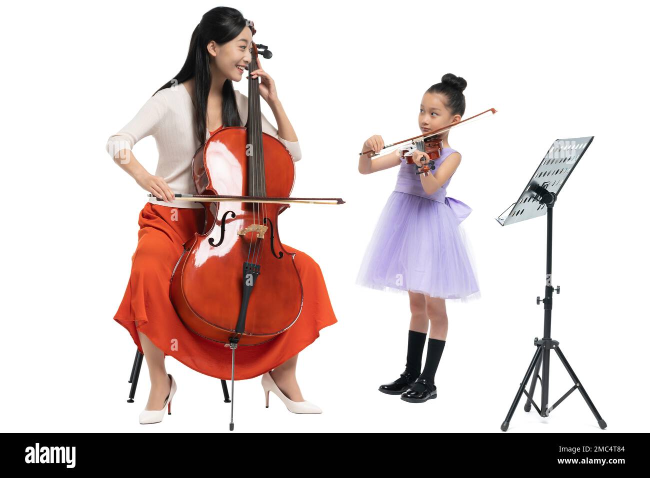 The female teacher guide girl playing Musical Instruments Stock Photo ...