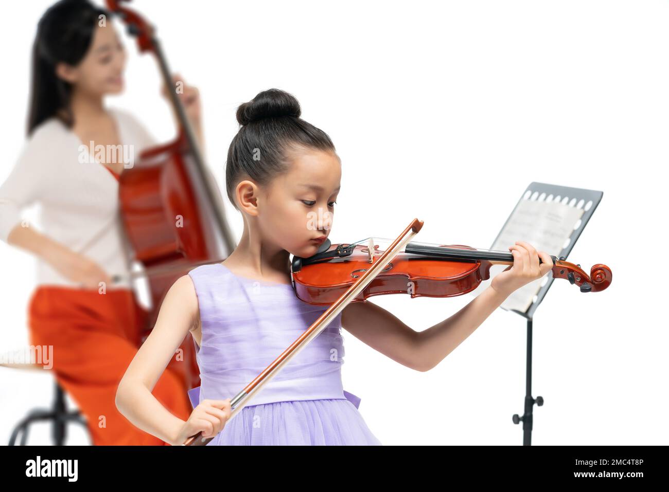 The female teacher guide girl playing Musical Instruments Stock Photo ...