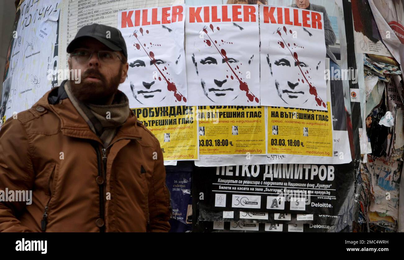 A man passes by posters depicting Russian President Vladimir Putin with ...