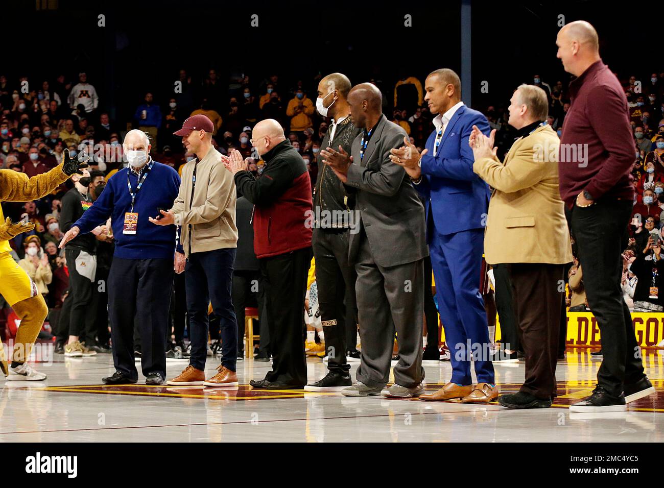 The 1982 Minnesota team, including coach Jim Dutcher, left, is honored ...